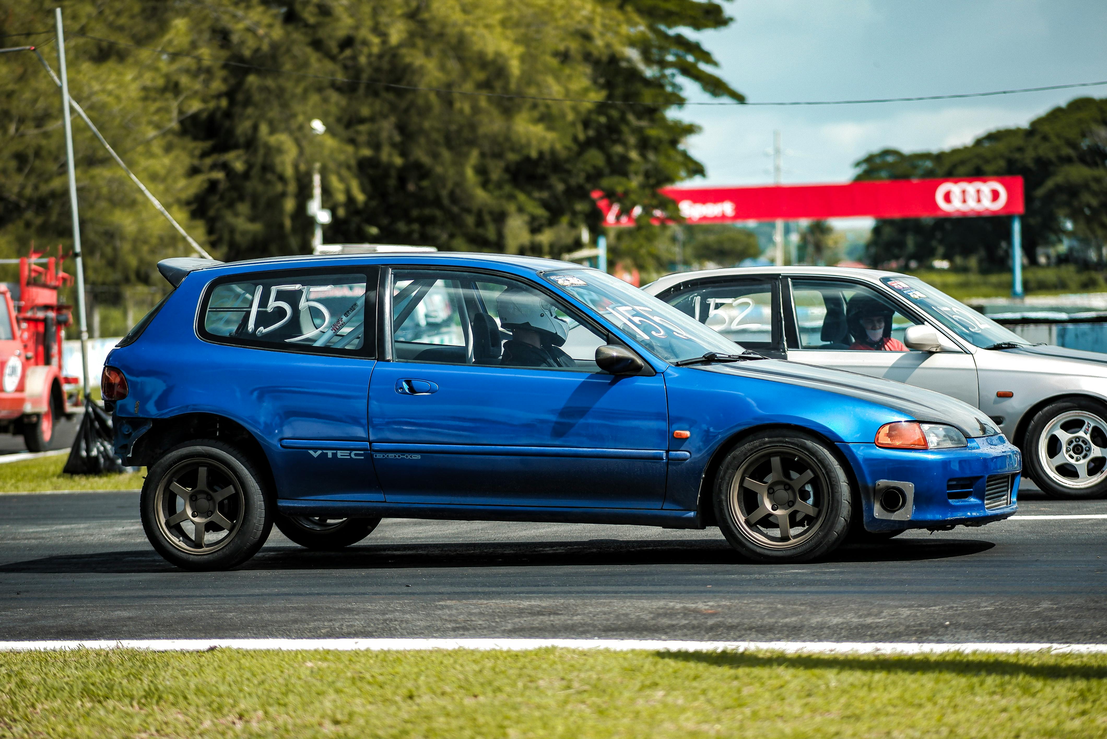 Blue Car Competing in a Daytime Race Event · Free Stock Photo