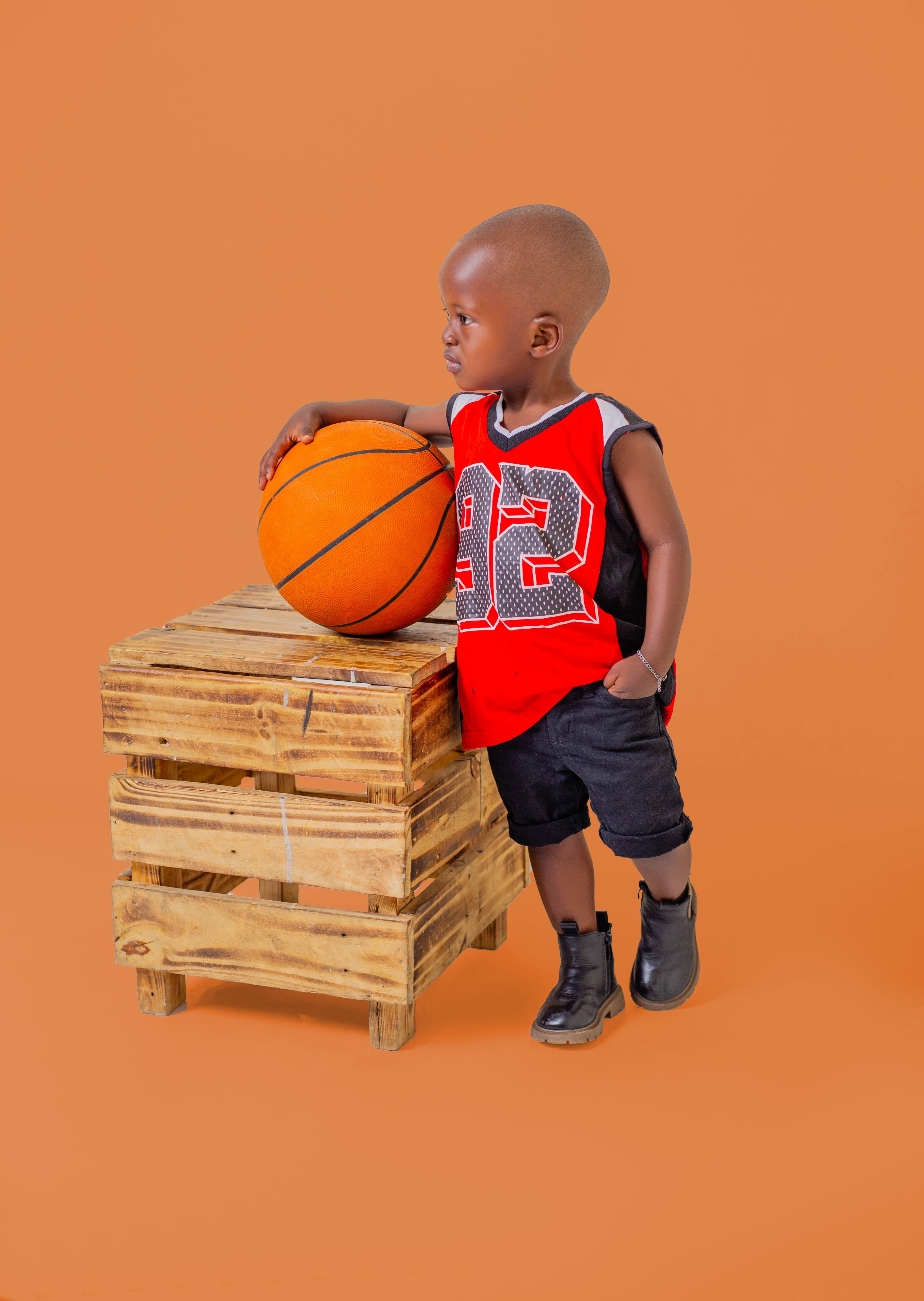 Child with Basketball on Wooden Crates · Free Stock Photo
