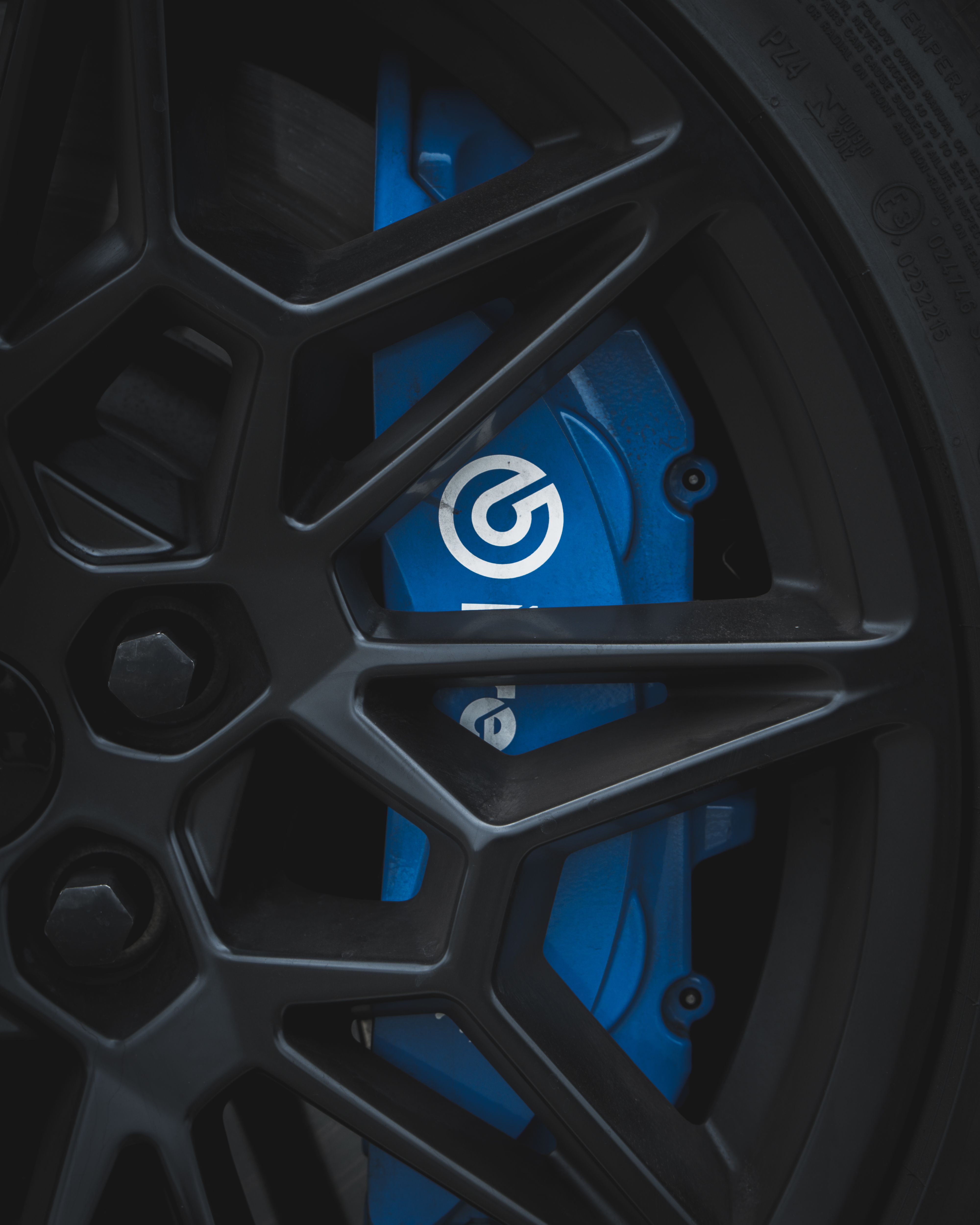 Close-up of Car Tire with Blue Brembo Brake Caliper · Free Stock Photo