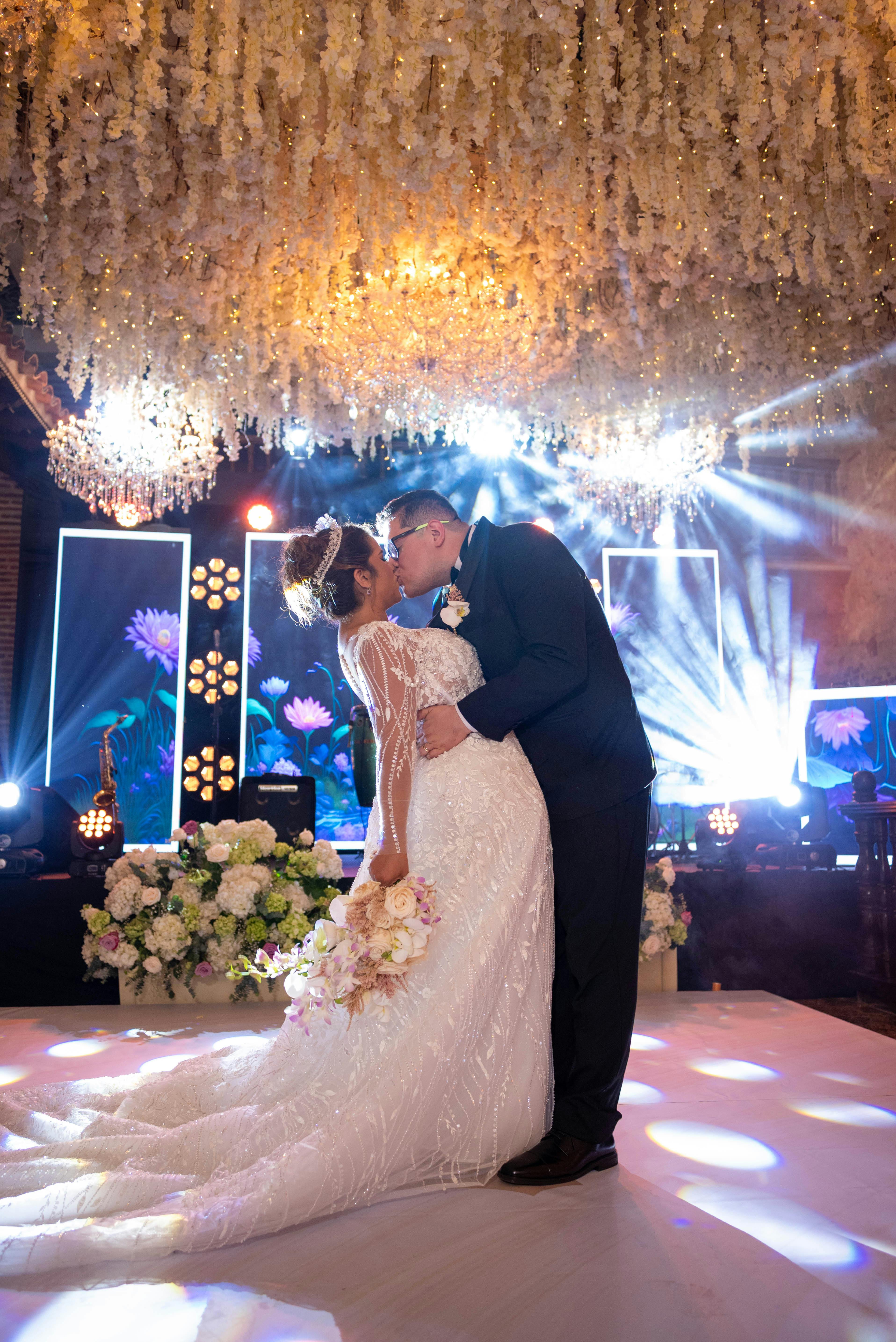 Romantic Wedding Kiss Under Floral Canopy · Free Stock Photo