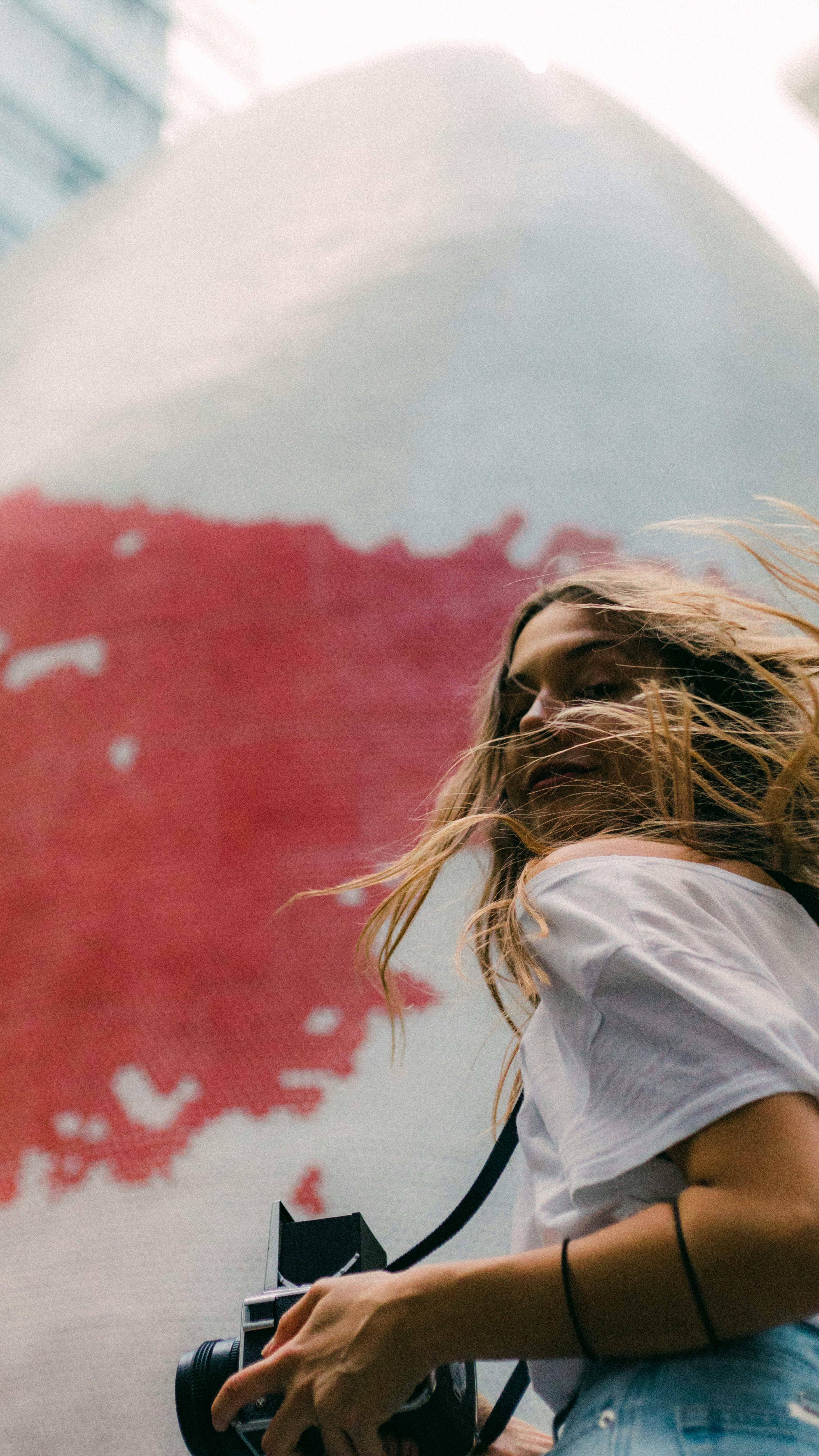 Woman Standing and Holding A Camera · Free Stock Photo