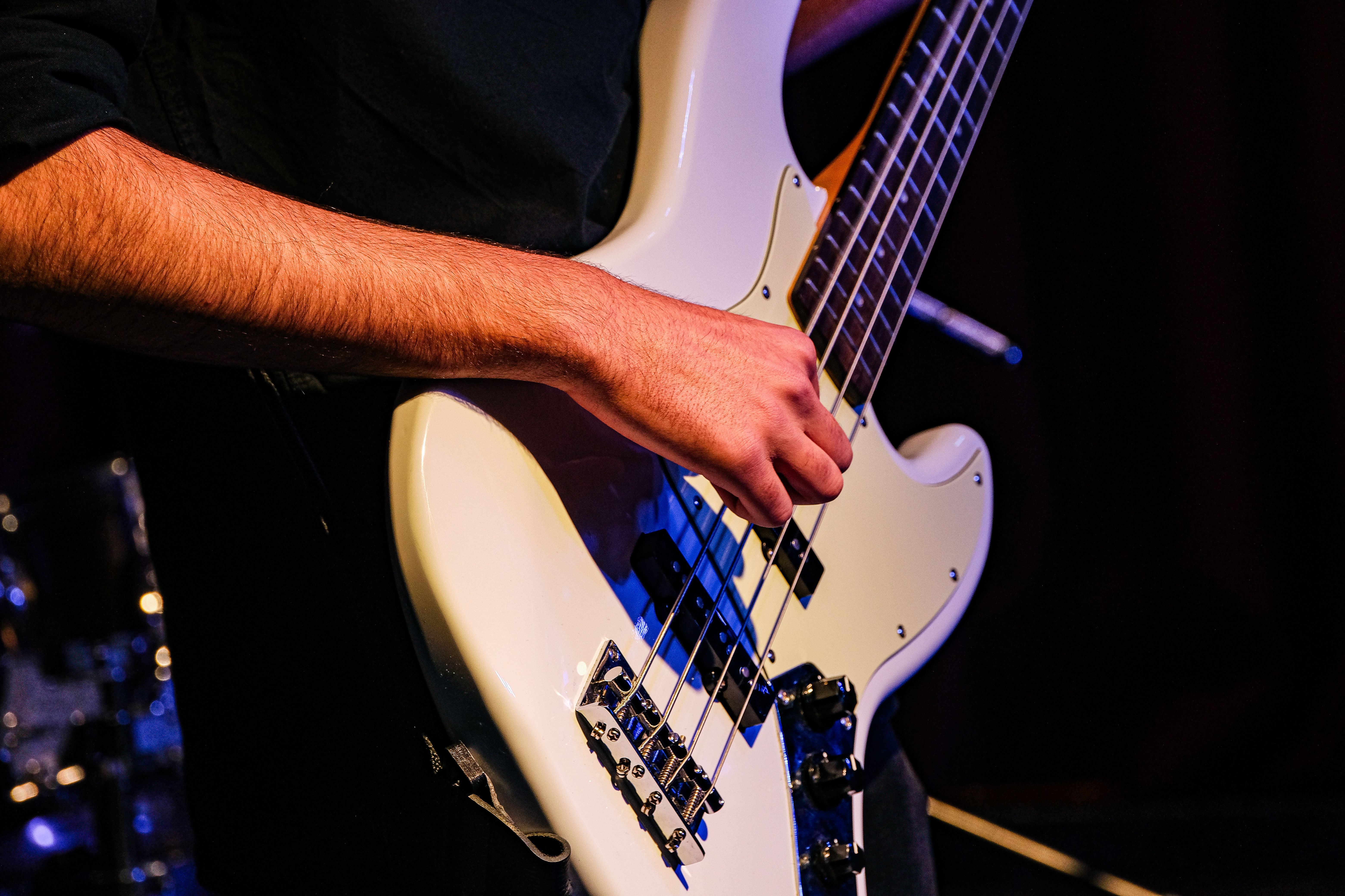 Close-up of Musician Playing Bass Guitar at Concert · Free Stock Photo