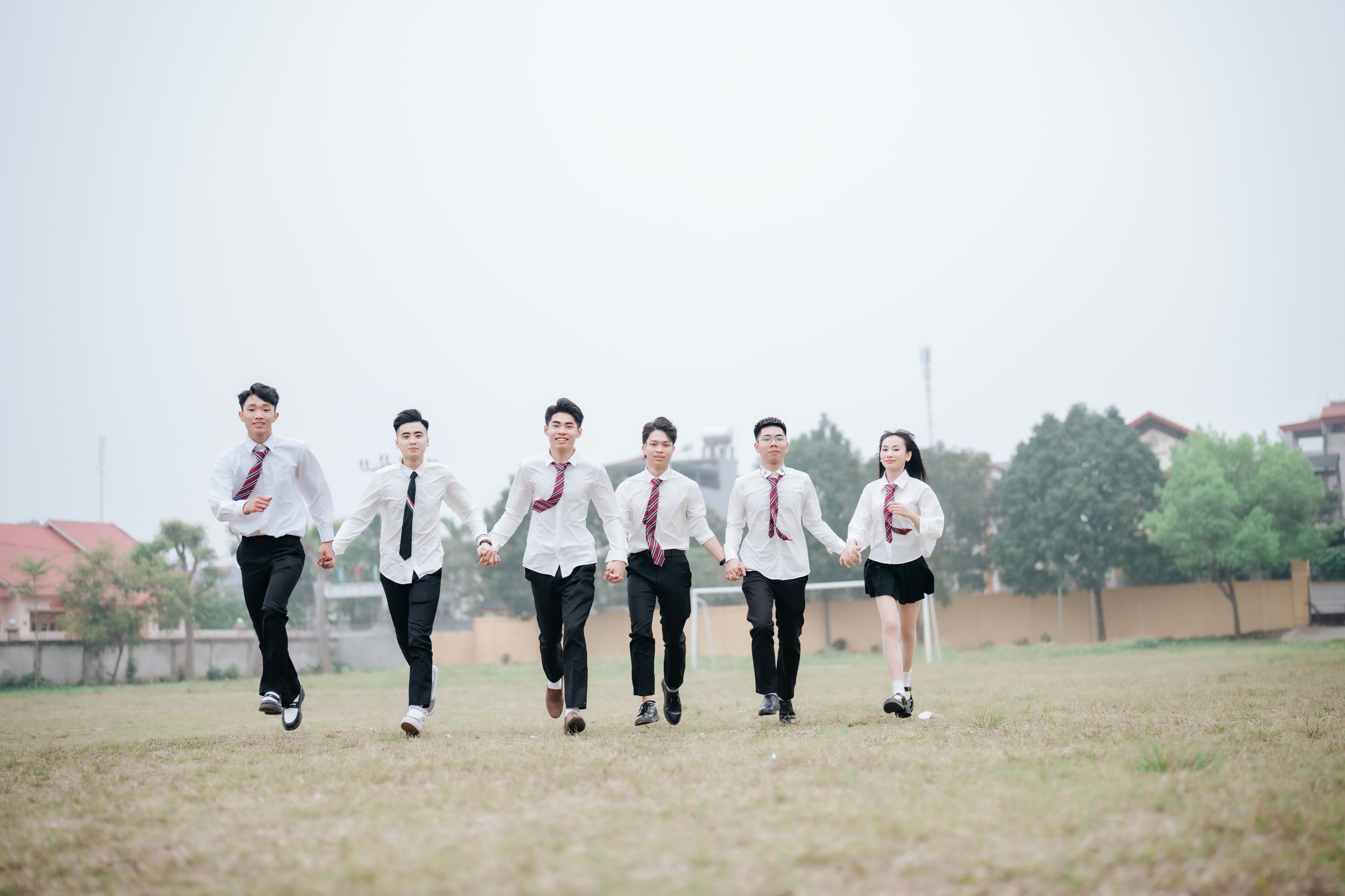 Group of Students Running Joyously Outdoors · Free Stock Photo