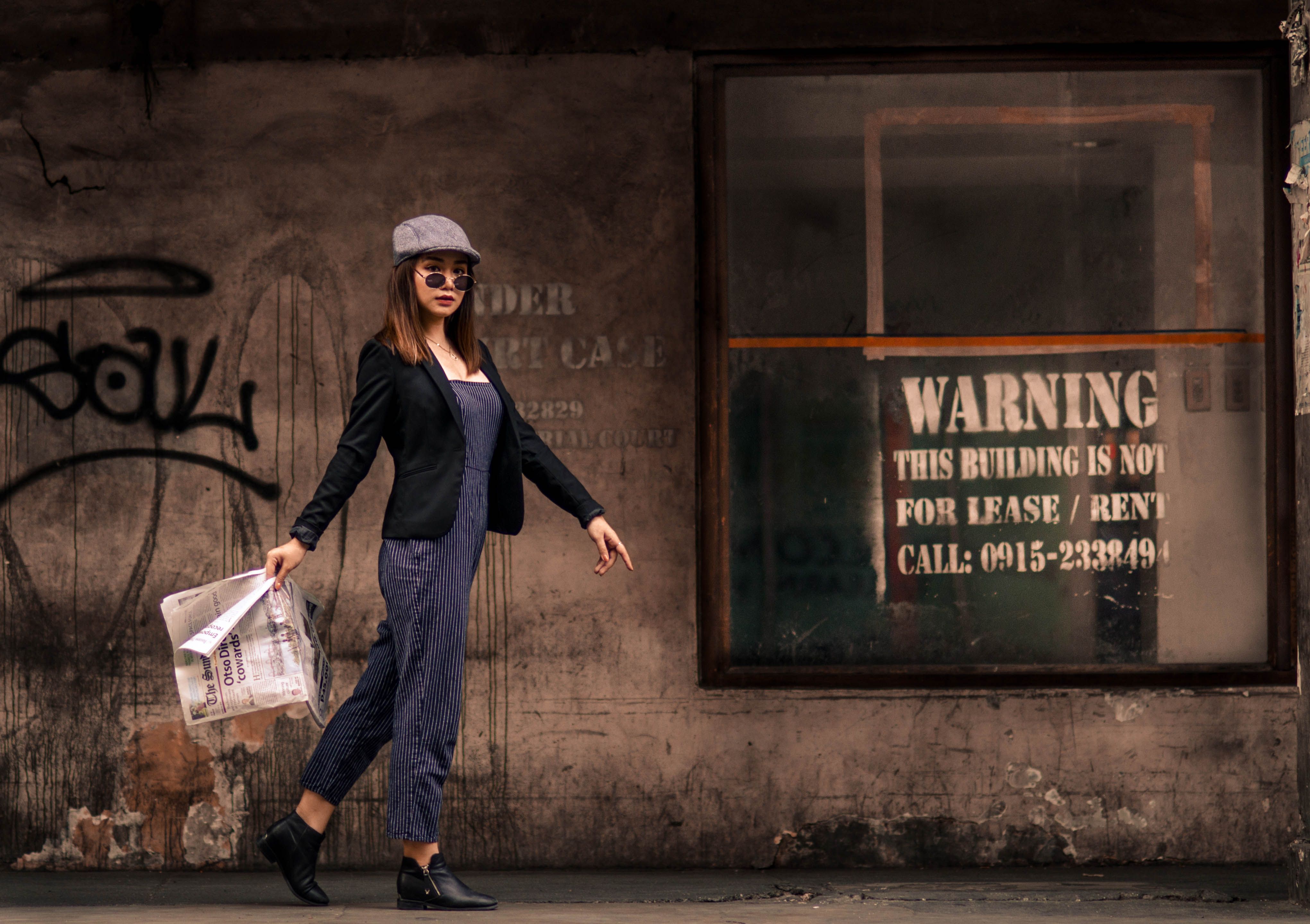Photo of Woman Walking on Pavement While Holding Newspaper · Free Stock ...