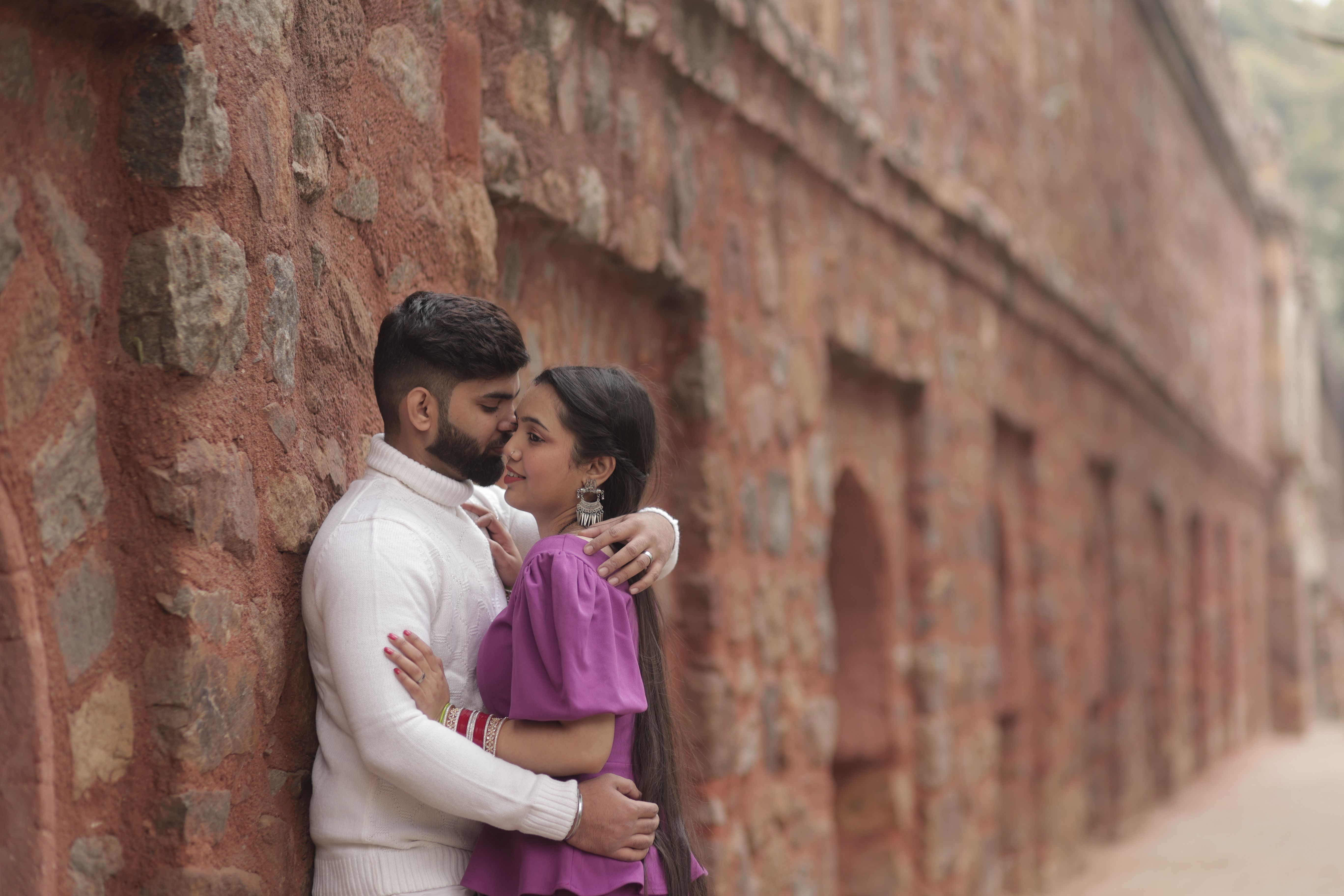 Romantic Couple Embracing by Historic Wall · Free Stock Photo