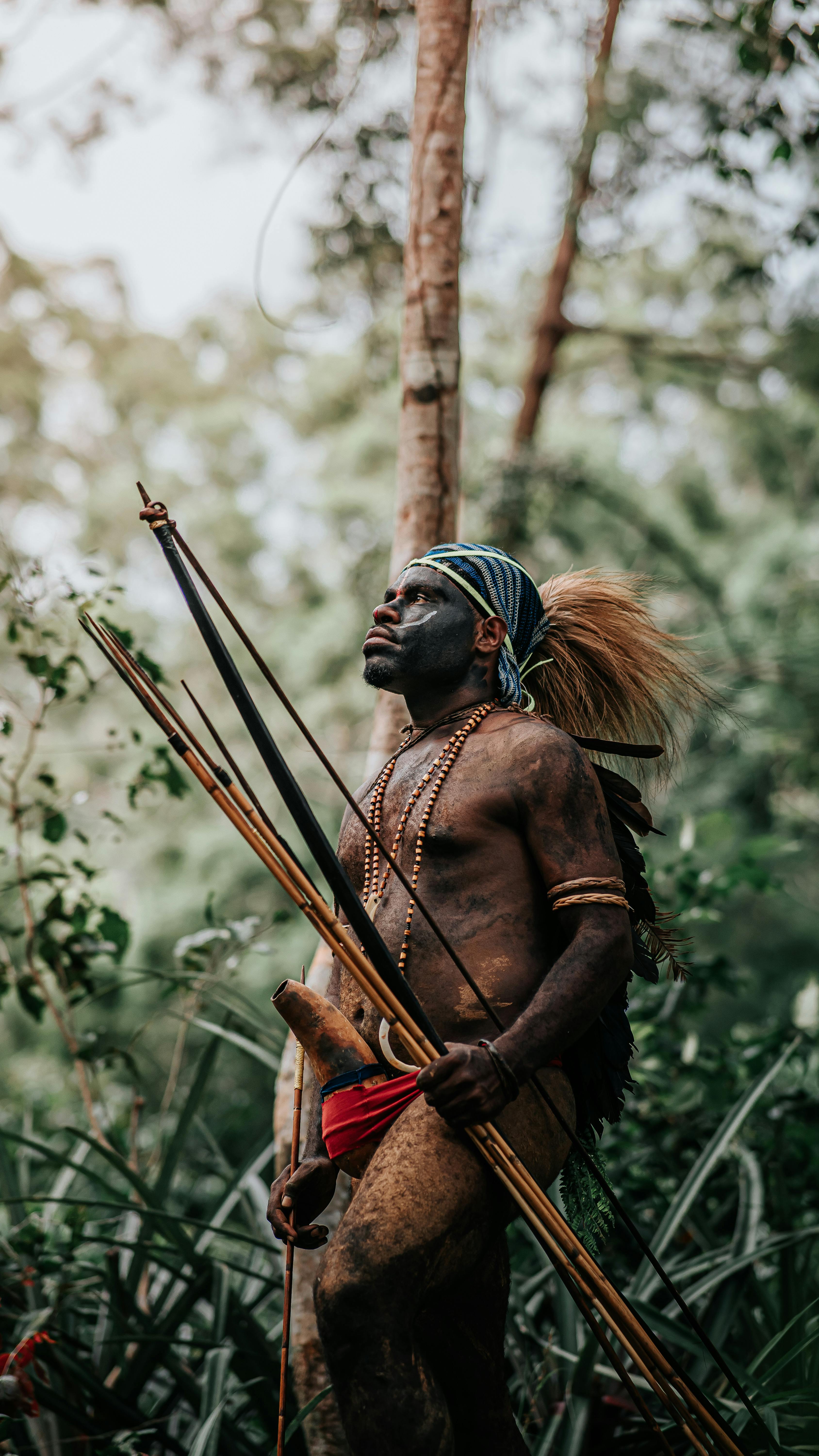 Traditional Indigenous Hunter in Lush Forest · Free Stock Photo