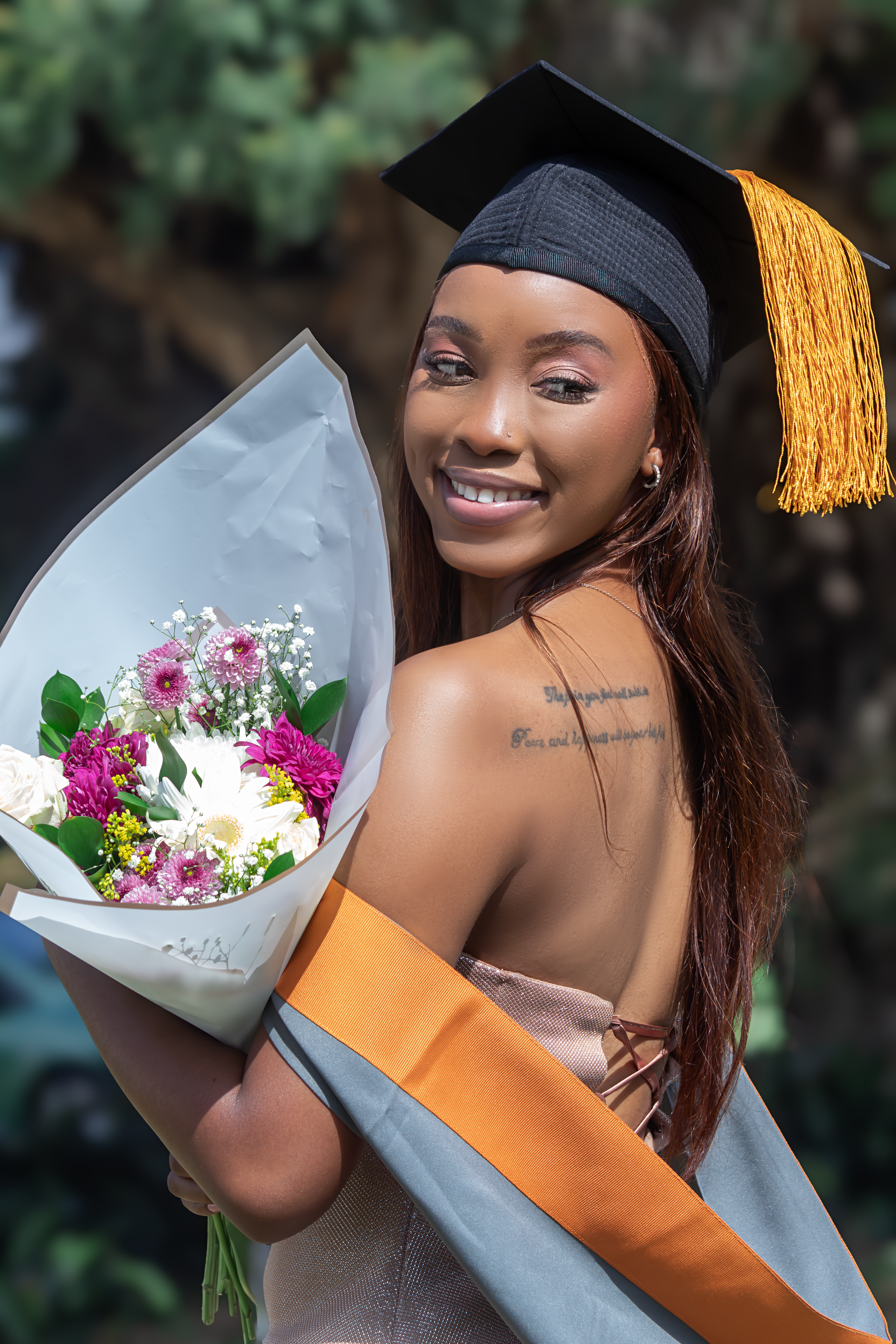 Joyous Graduate Celebrating with Flowers · Free Stock Photo