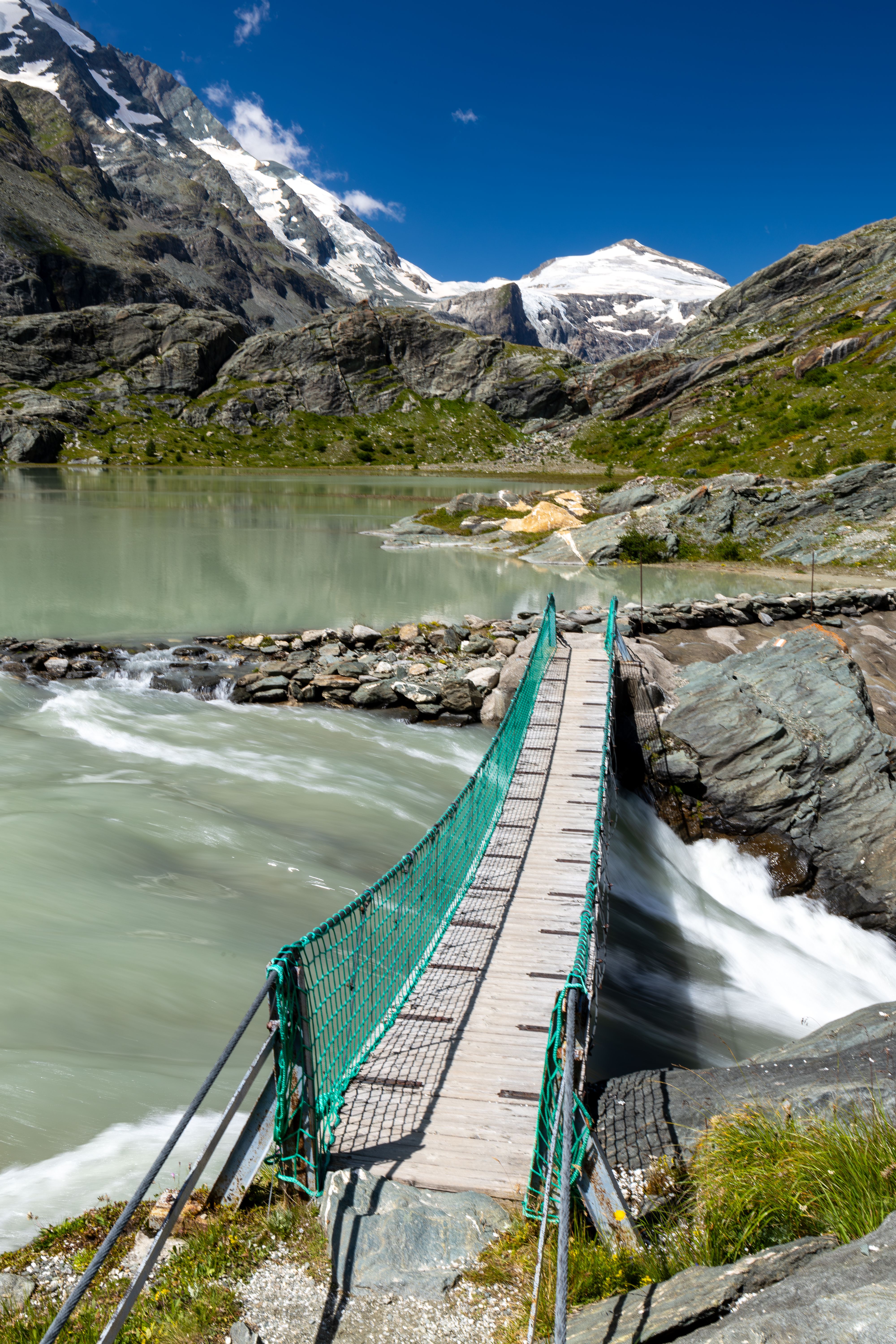 Scenic Suspension Bridge Over Alpine Lake · Free Stock Photo