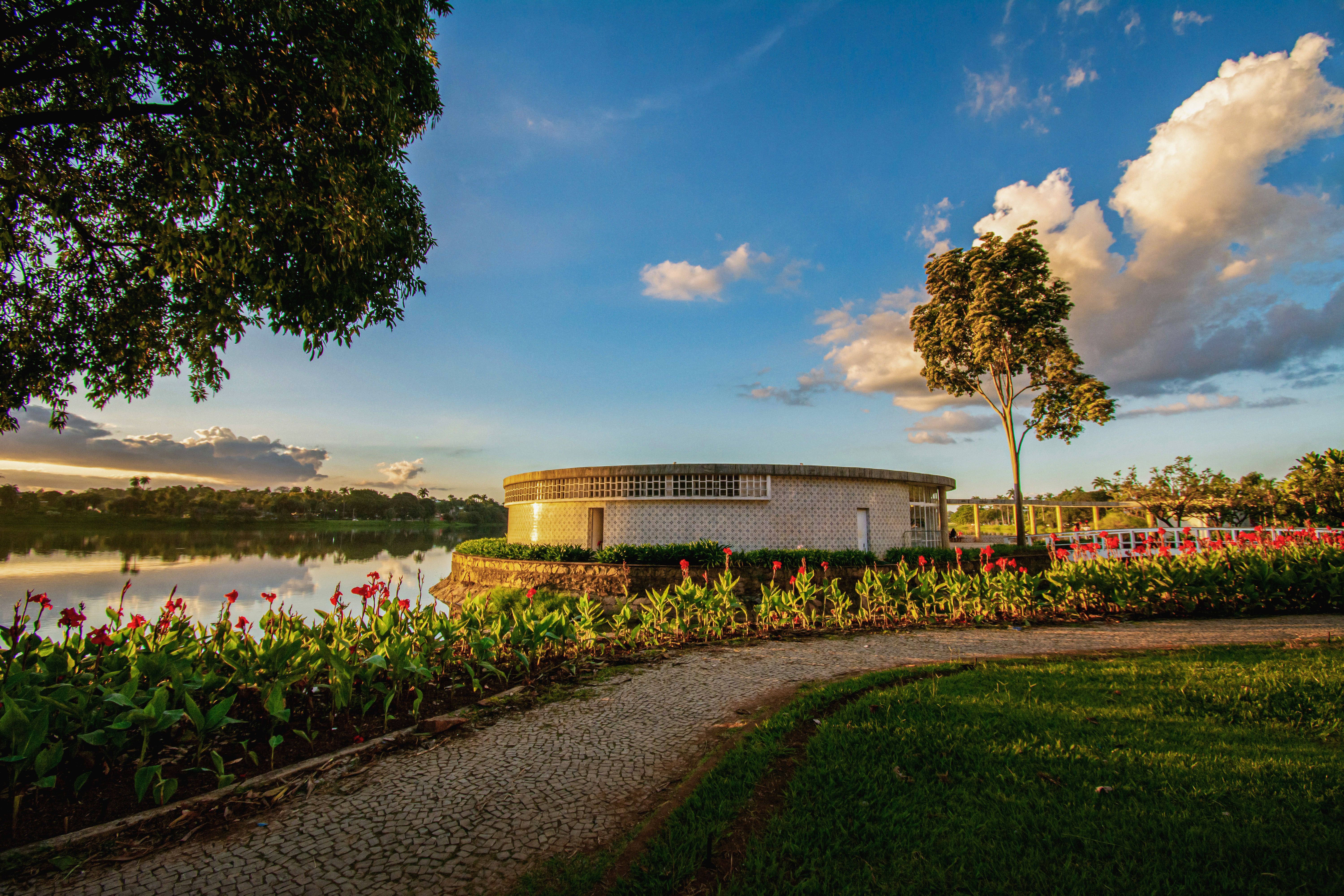 Scenic View of Circular Building by Lake at Sunset · Free Stock Photo
