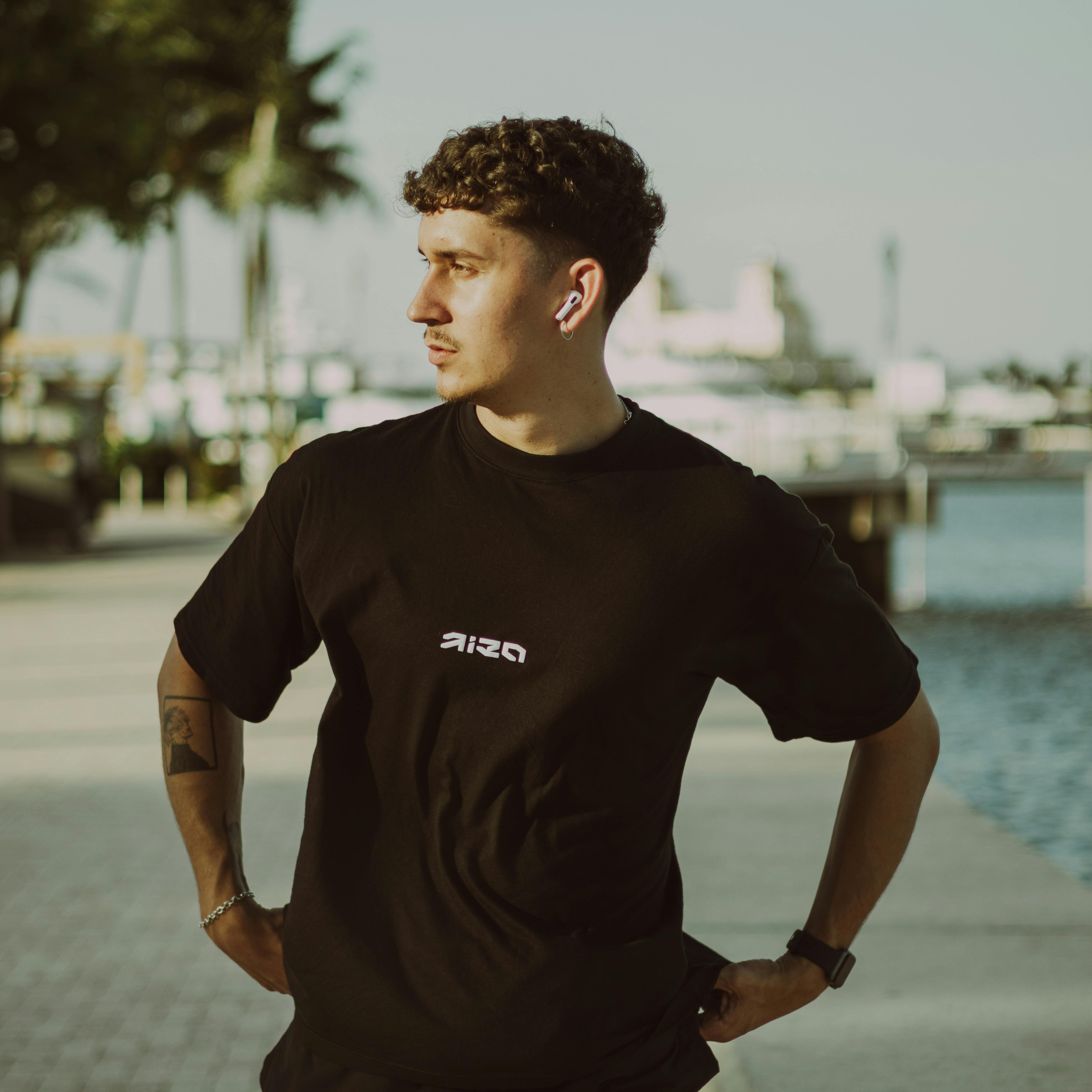 Young Man with Earbuds by Waterfront · Free Stock Photo