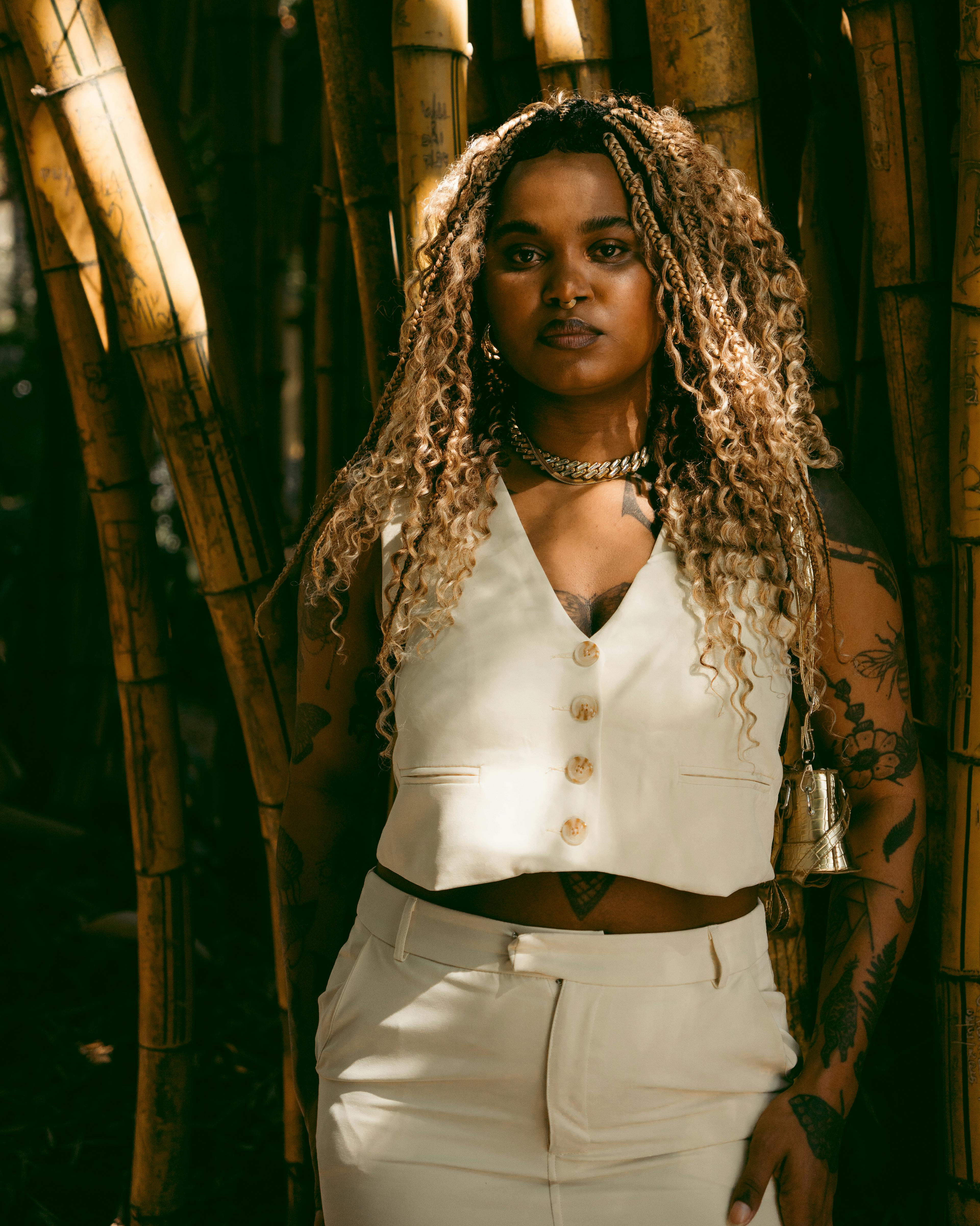 Stylish Woman Posing Amid Bamboo Stalks Outdoors · Free Stock Photo
