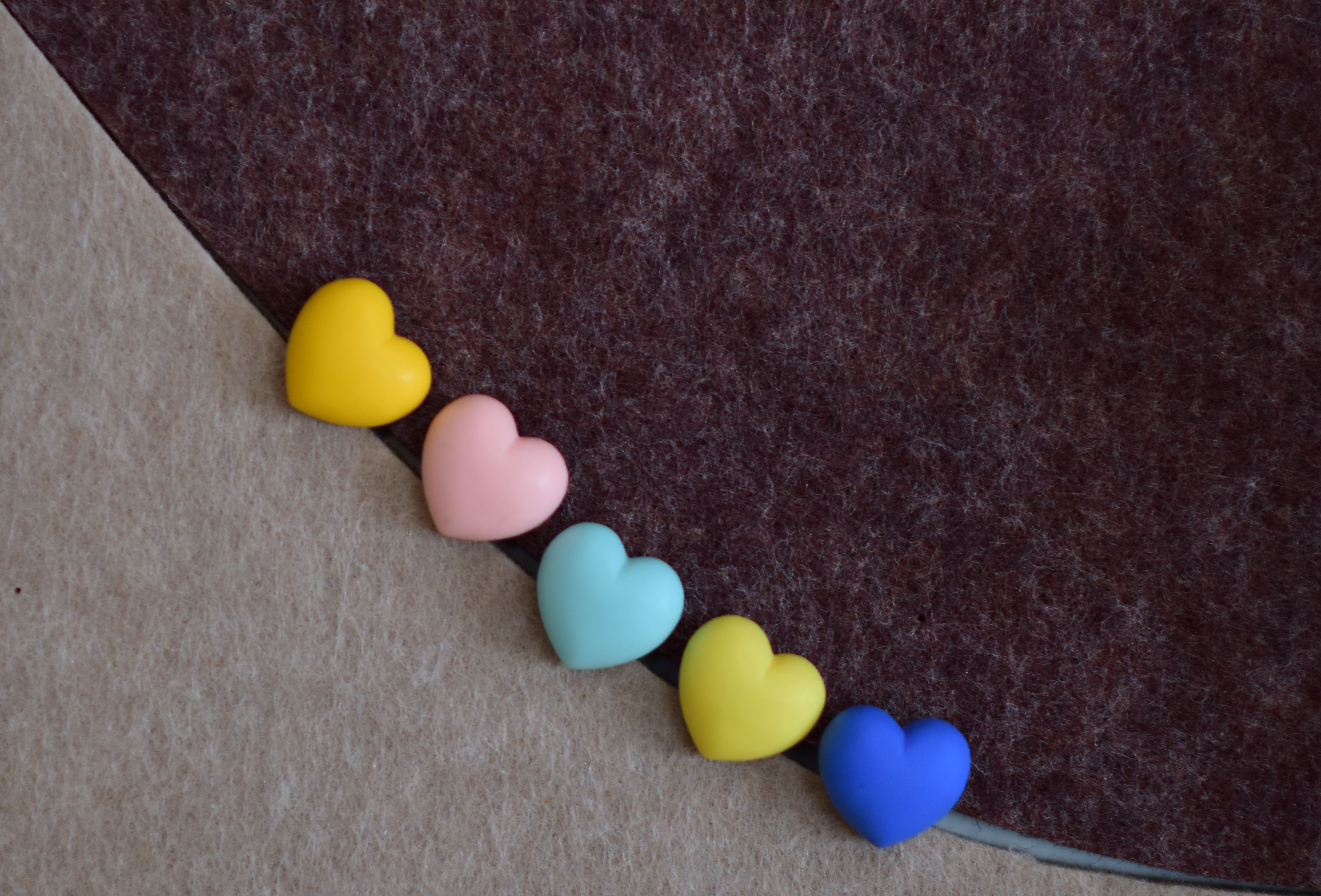 Colorful Heart-Shaped Push Pins on Textured Background · Free Stock Photo