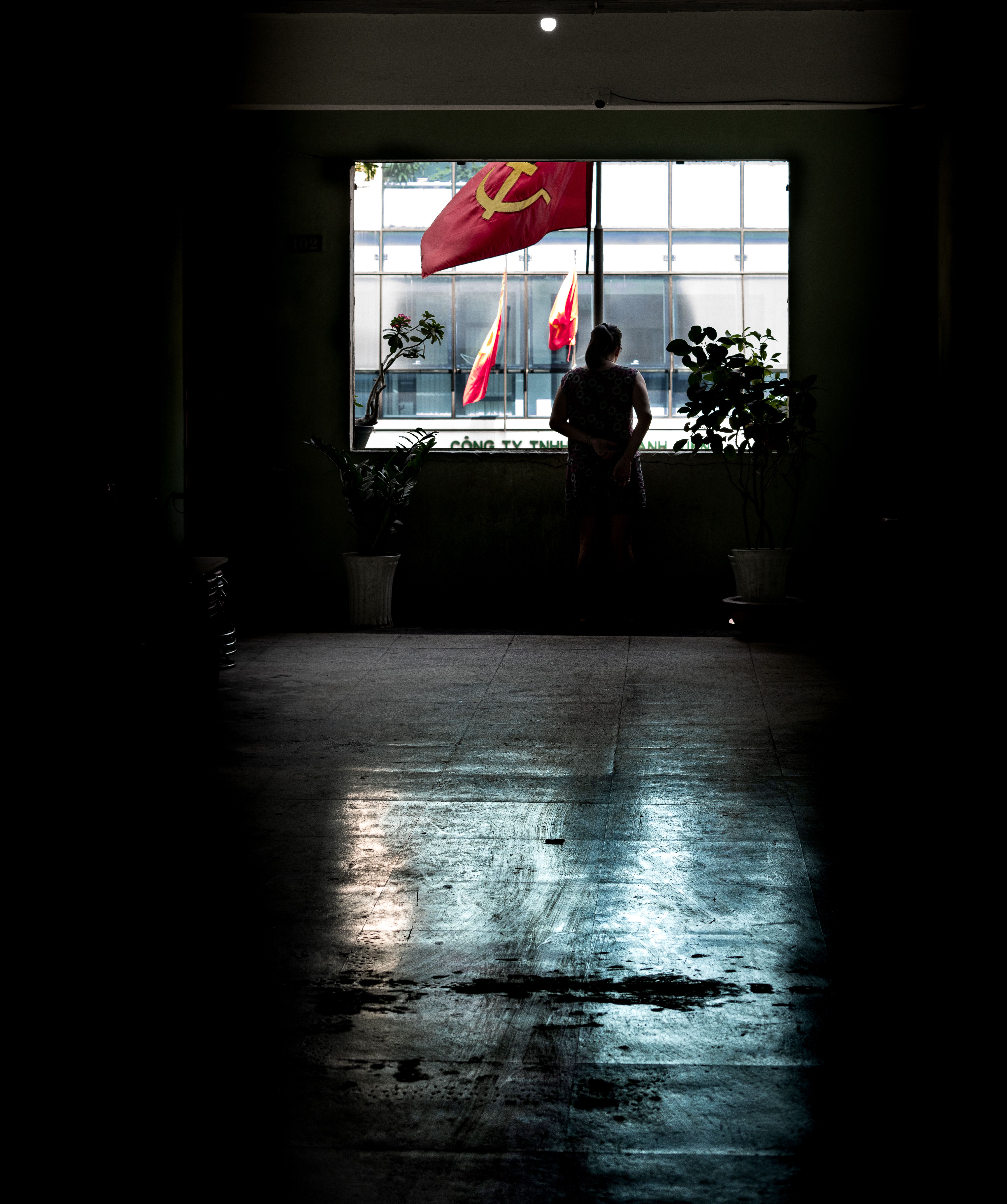Silhouette by Window with Communist Flag Display · Free Stock Photo