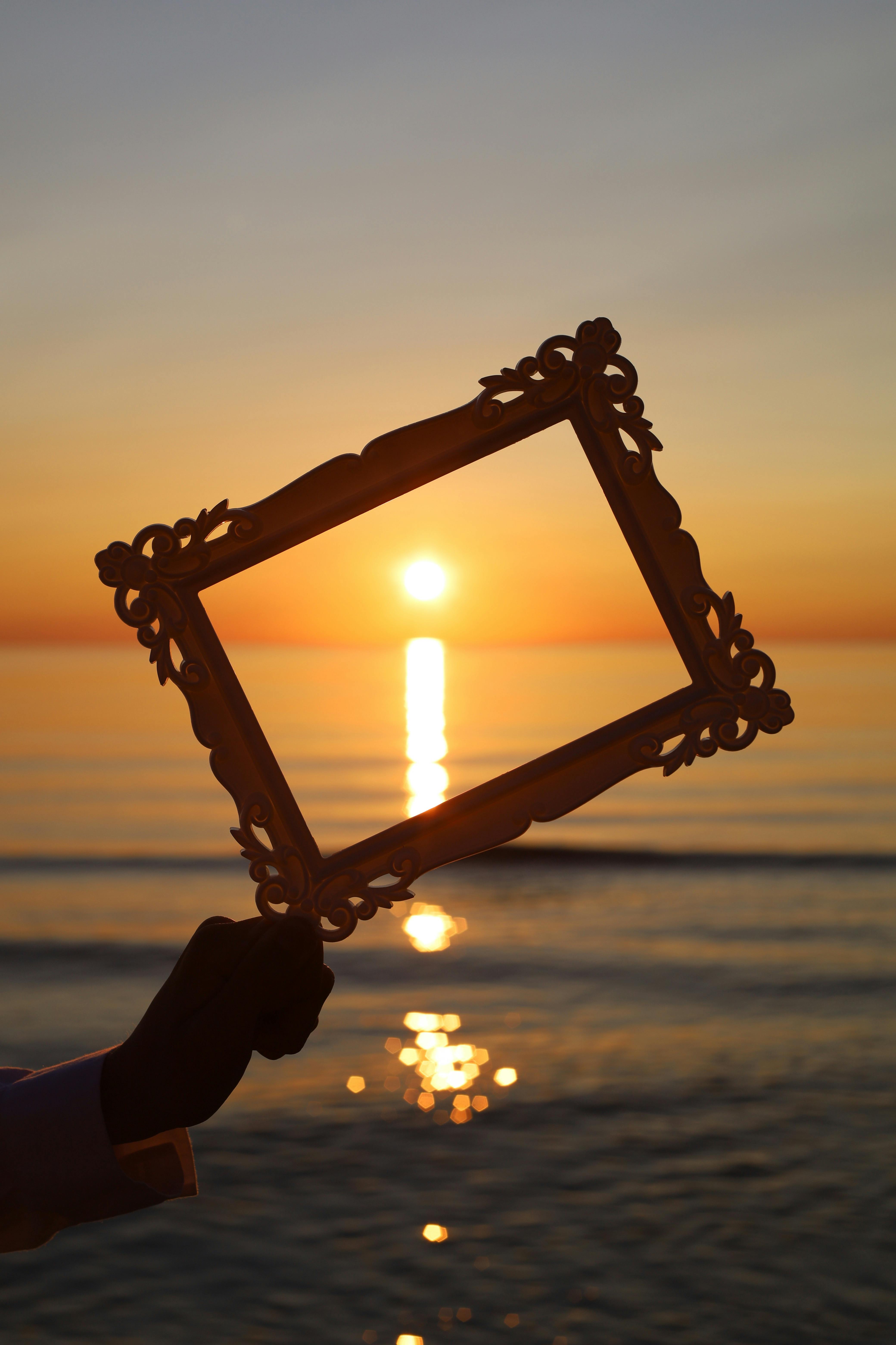 Framed Sunset Over Ocean at Golden Hour · Free Stock Photo