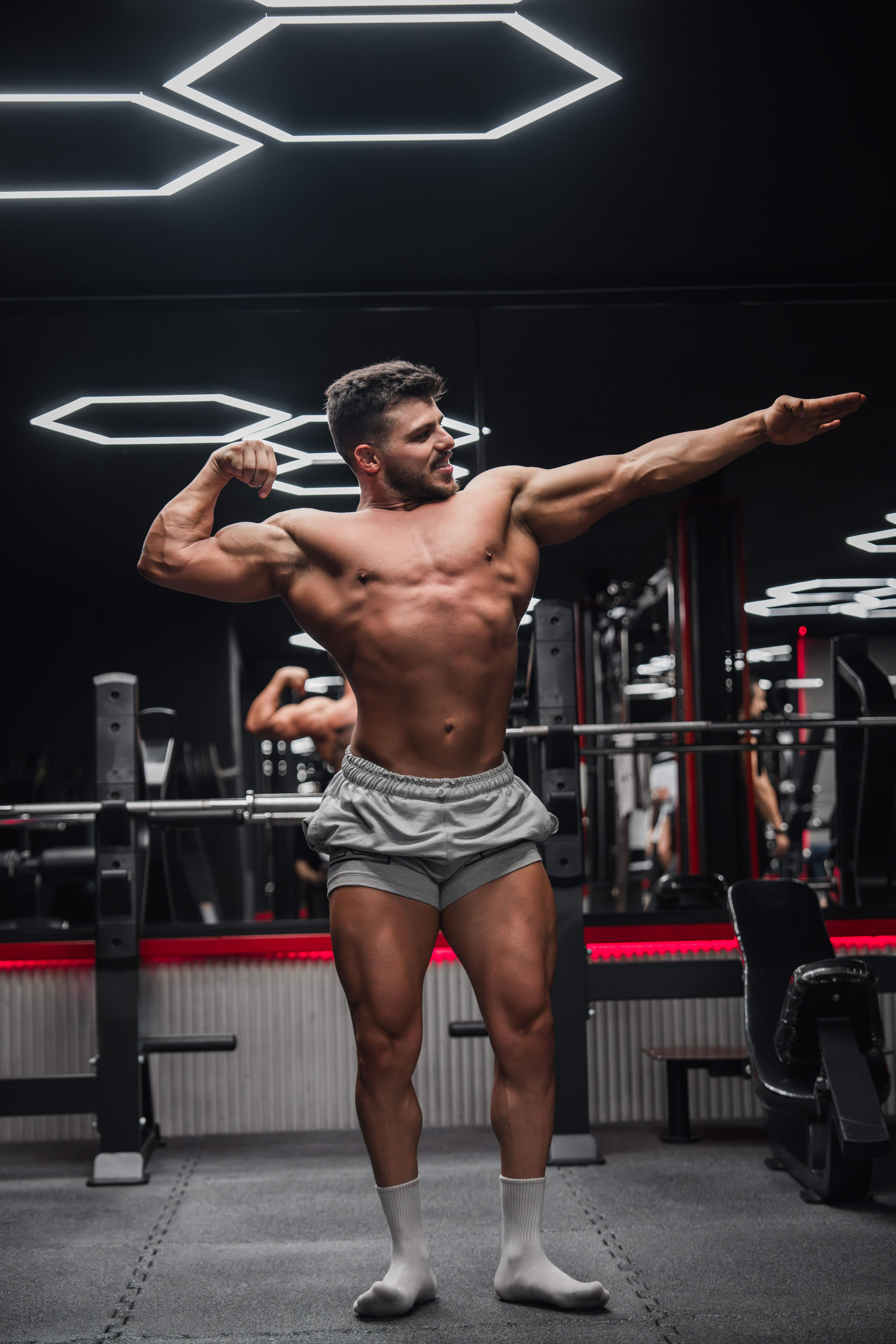 Muscular Man Posing in Modern Gym Environment · Free Stock Photo
