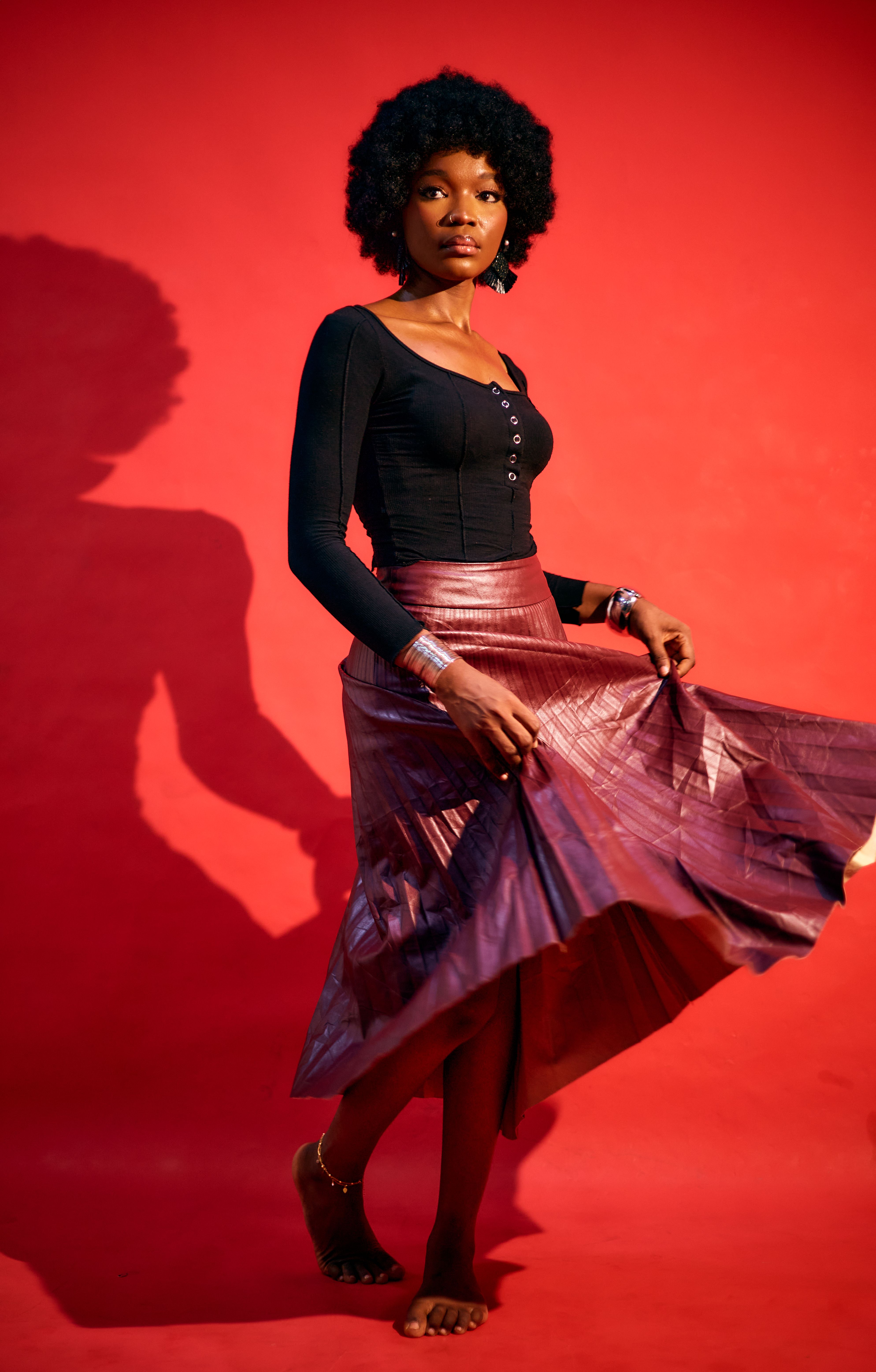 Elegant Woman Poses in Vibrant Red Studio · Free Stock Photo