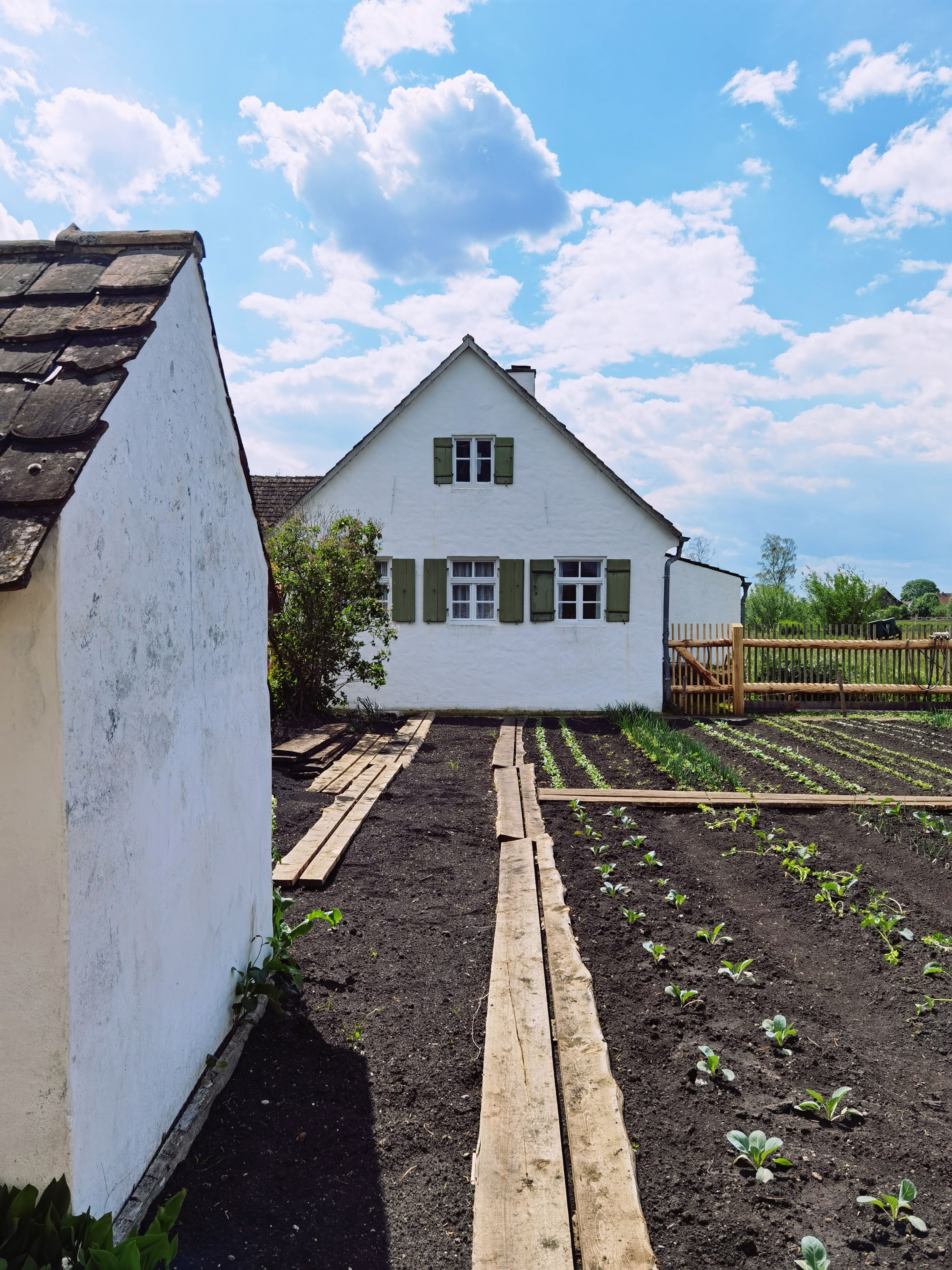 Rustic Farmhouse with Vegetable Garden Under Blue Sky · Free Stock Photo