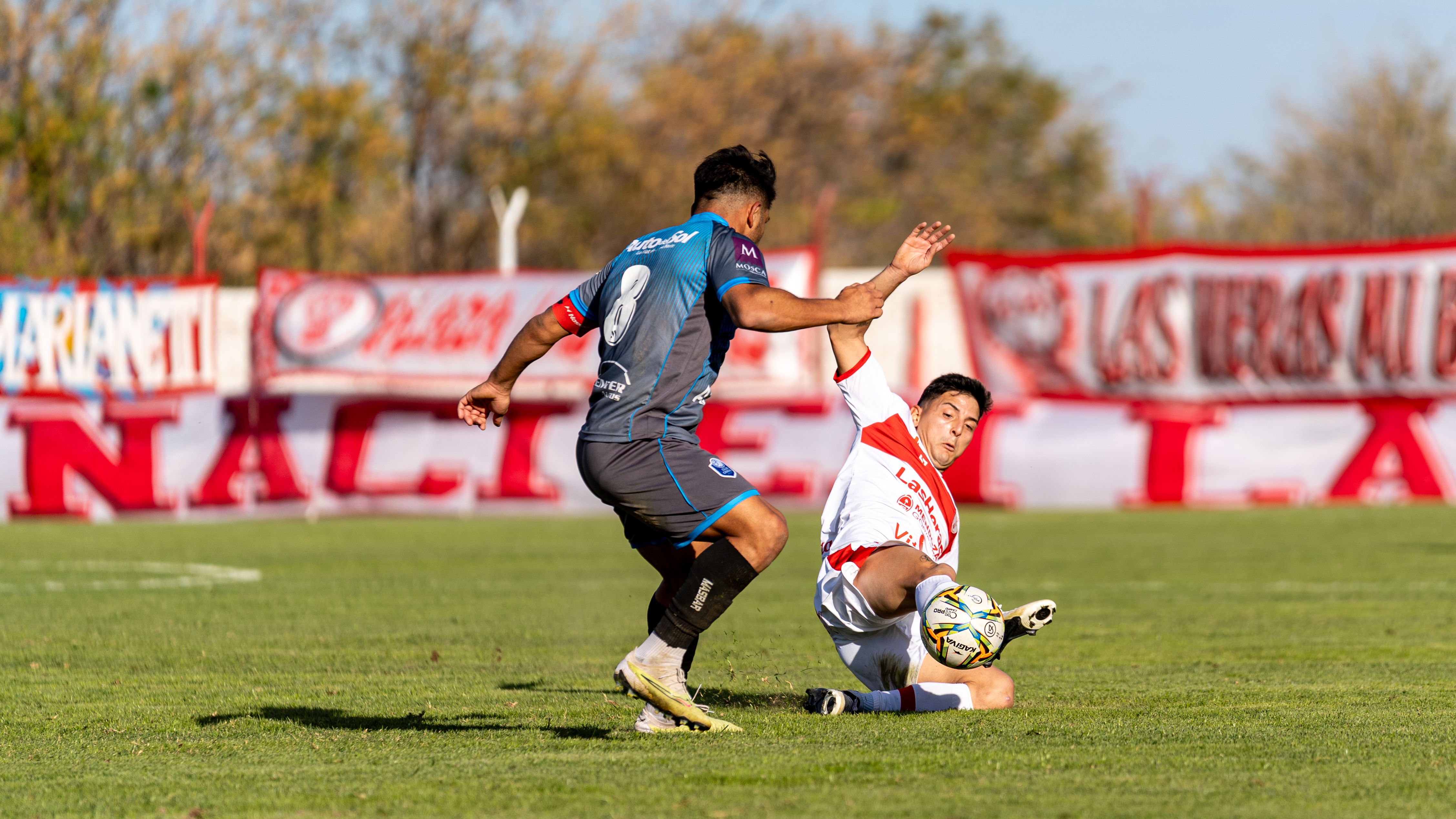 Intense Soccer Match Tackle on Green Field · Free Stock Photo