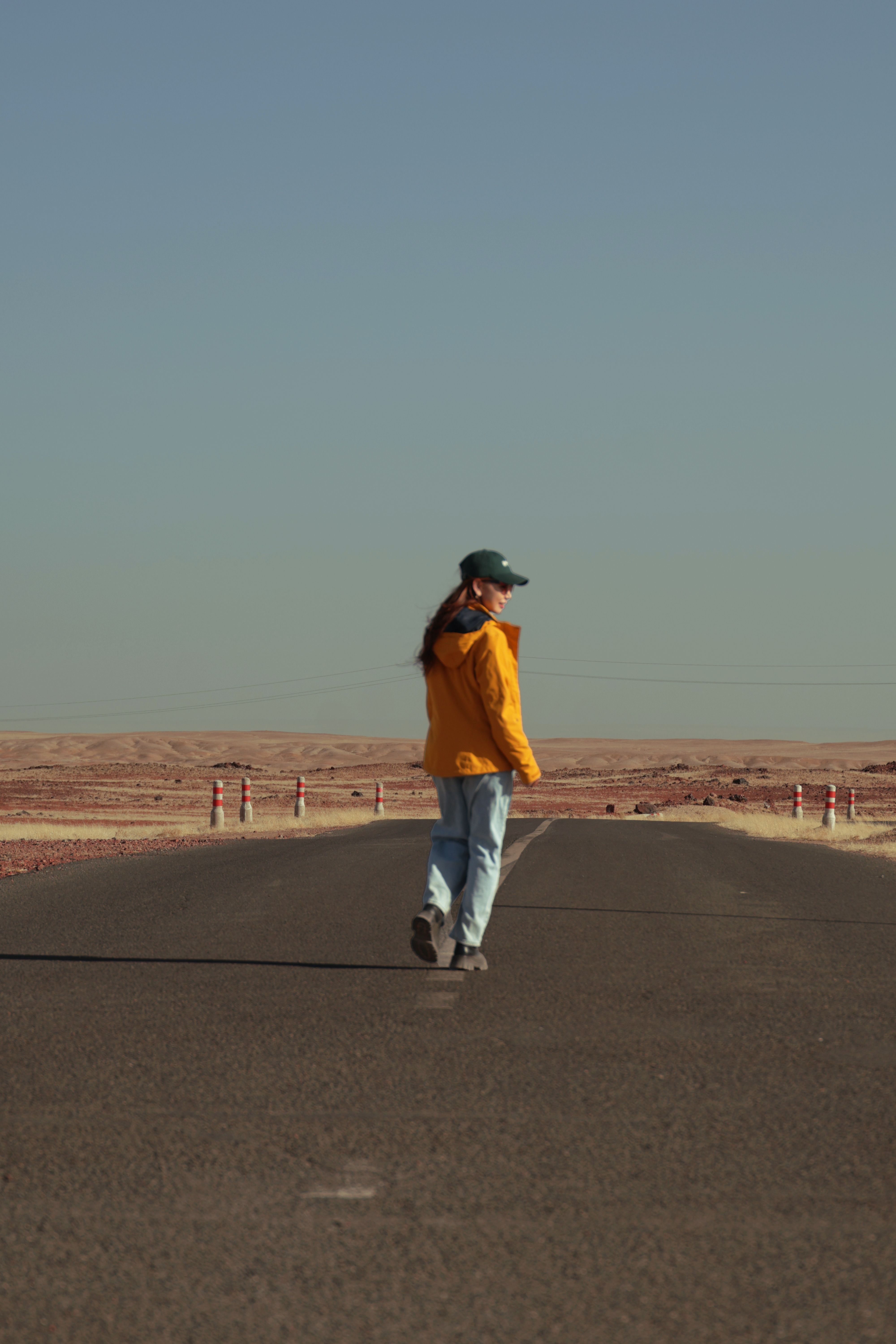 Young Woman Walking on Deserted Road · Free Stock Photo