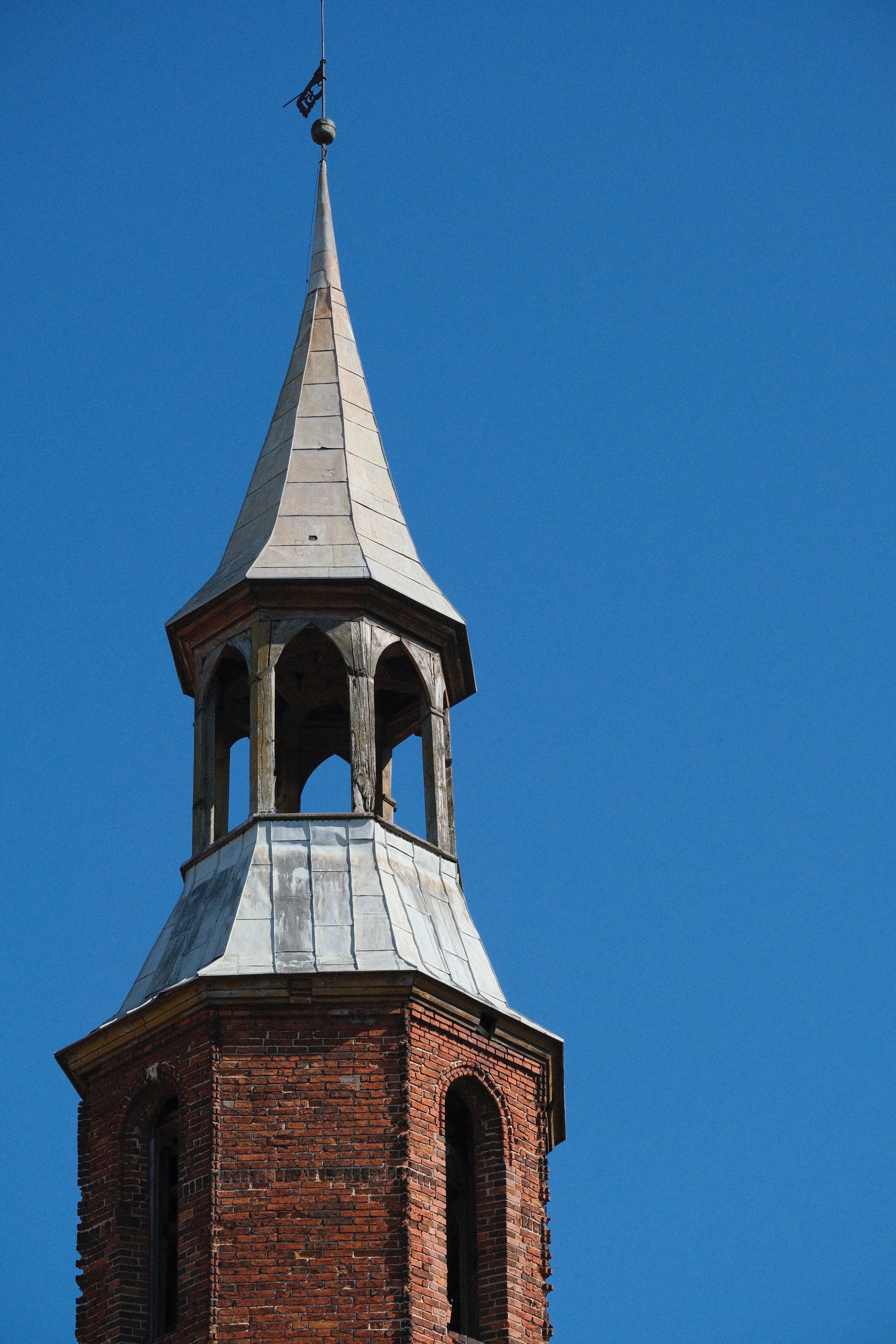 Historic Brick Church Tower against Clear Sky · Free Stock Photo