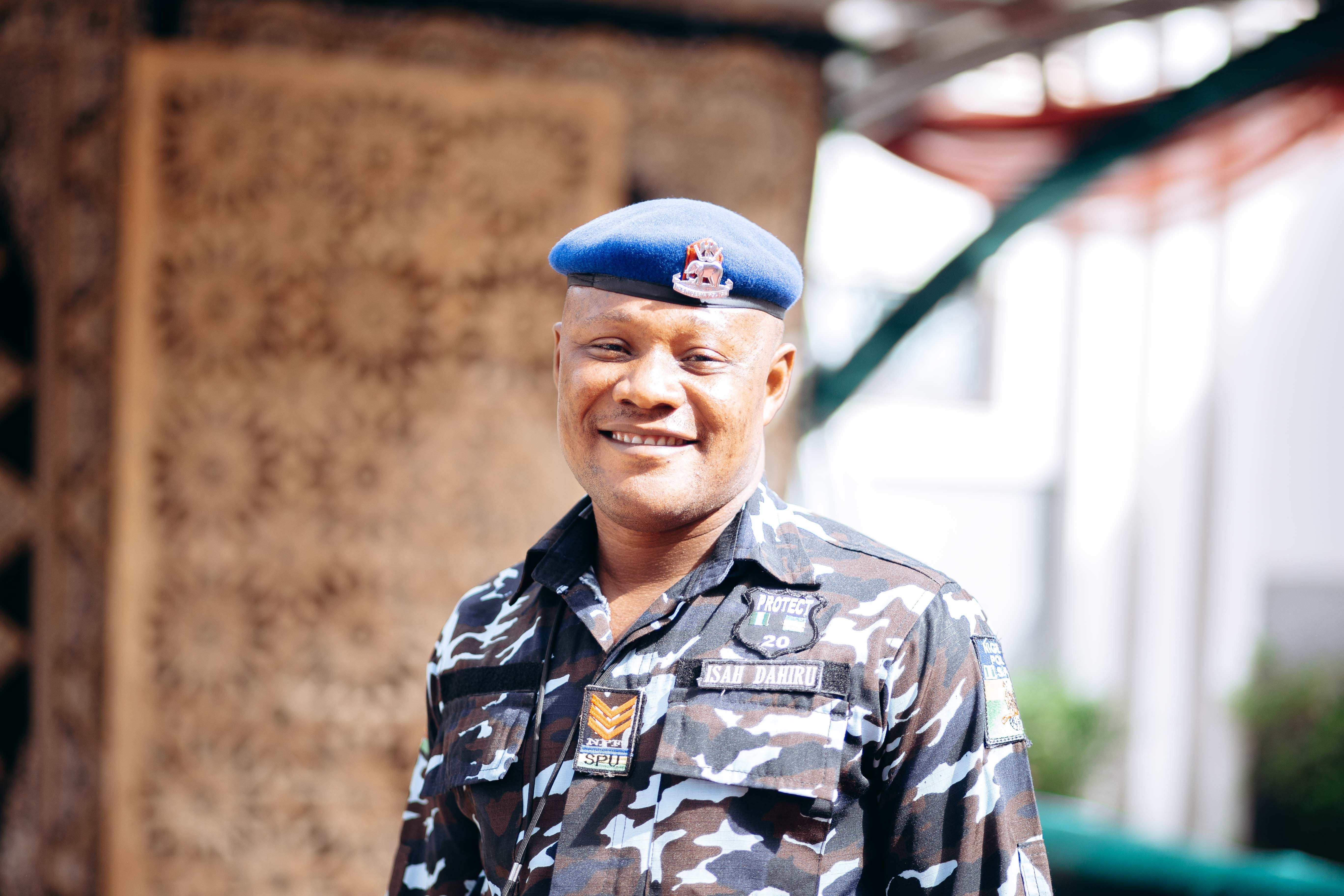 Smiling Nigerian Police Officer in Uniform Outdoors · Free Stock Photo