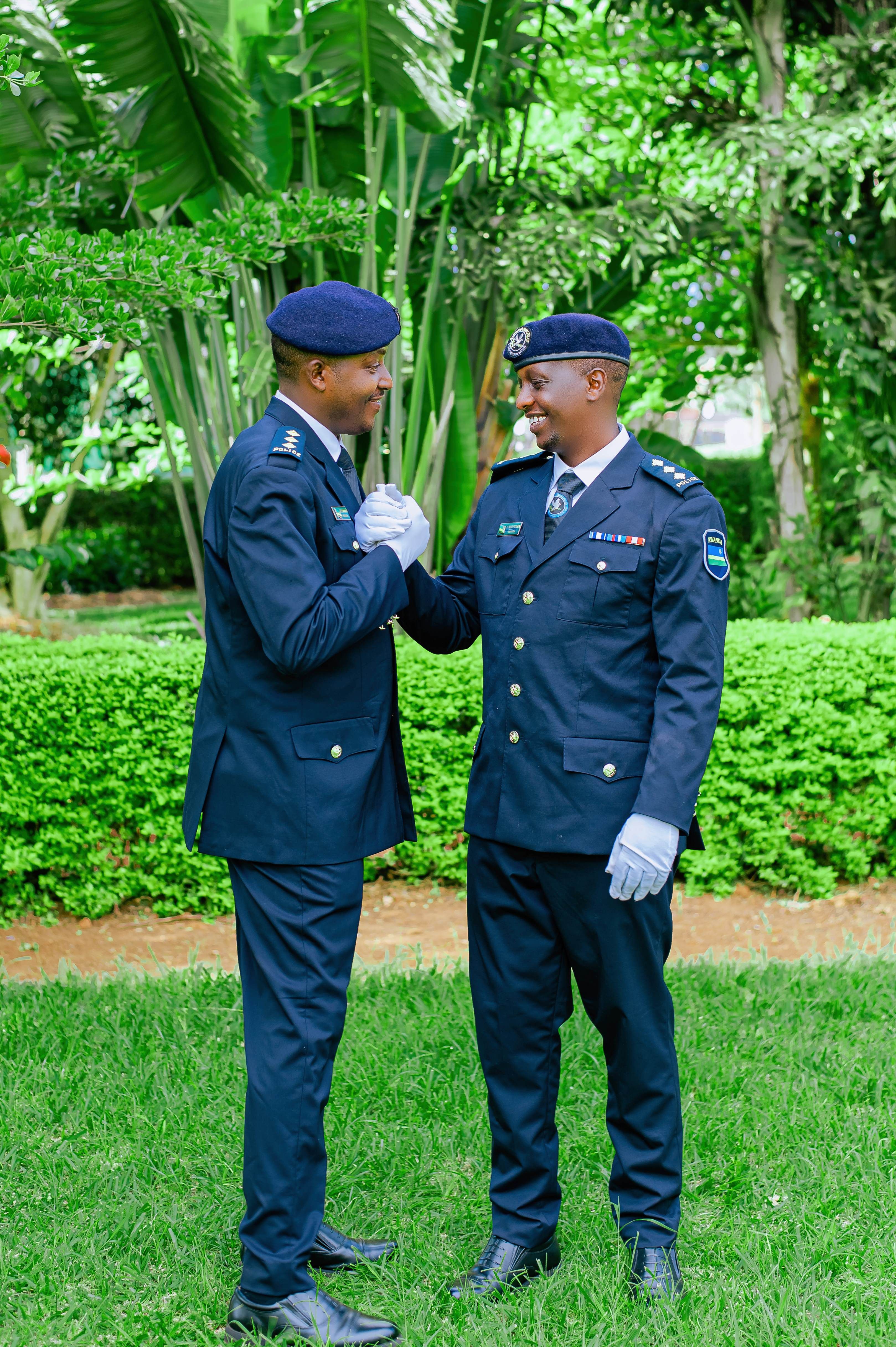 Two Smiling Police Officers Shaking Hands Outdoors · Free Stock Photo