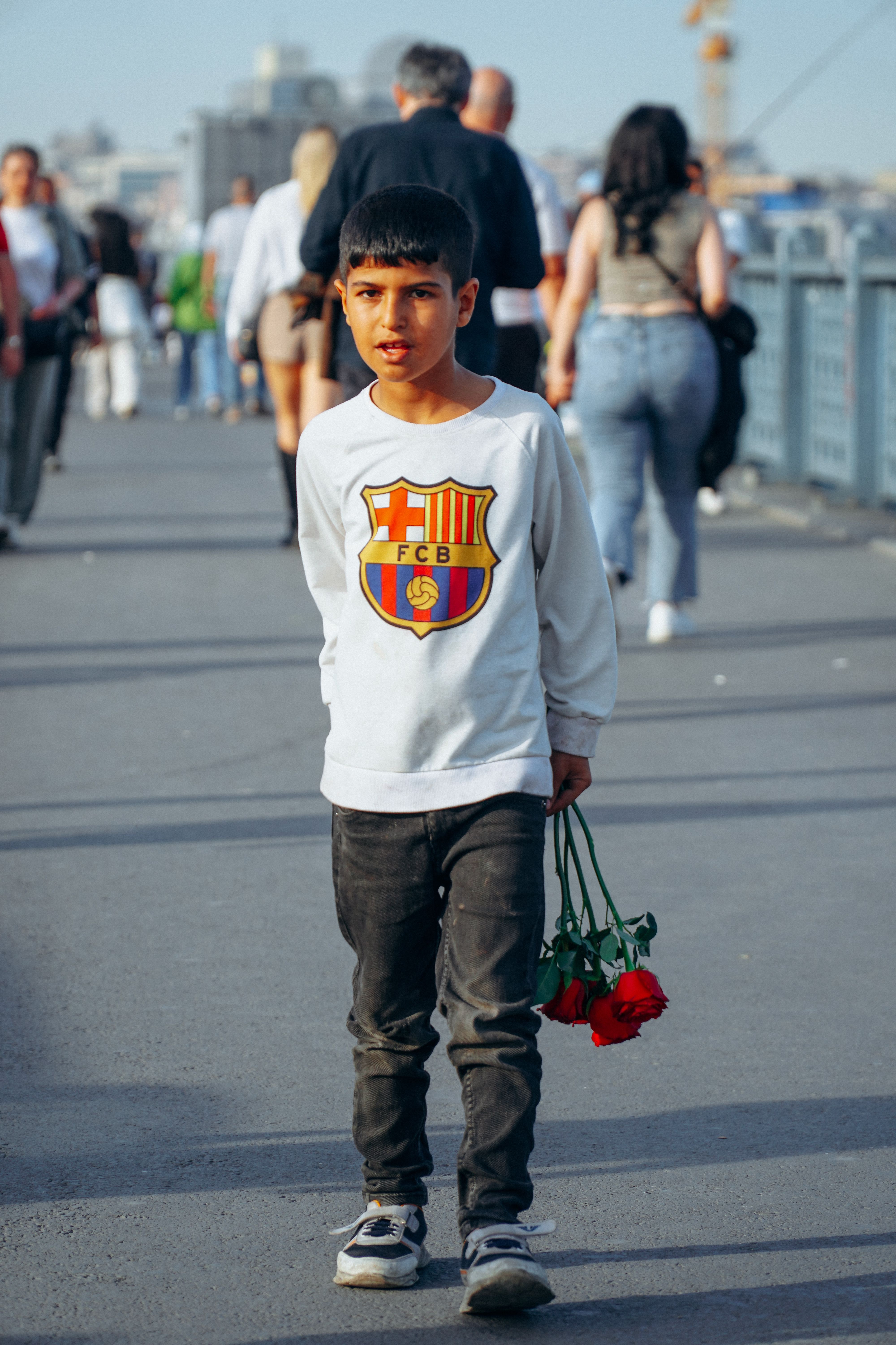 Young Boy with Roses Walking on Busy Street · Free Stock Photo