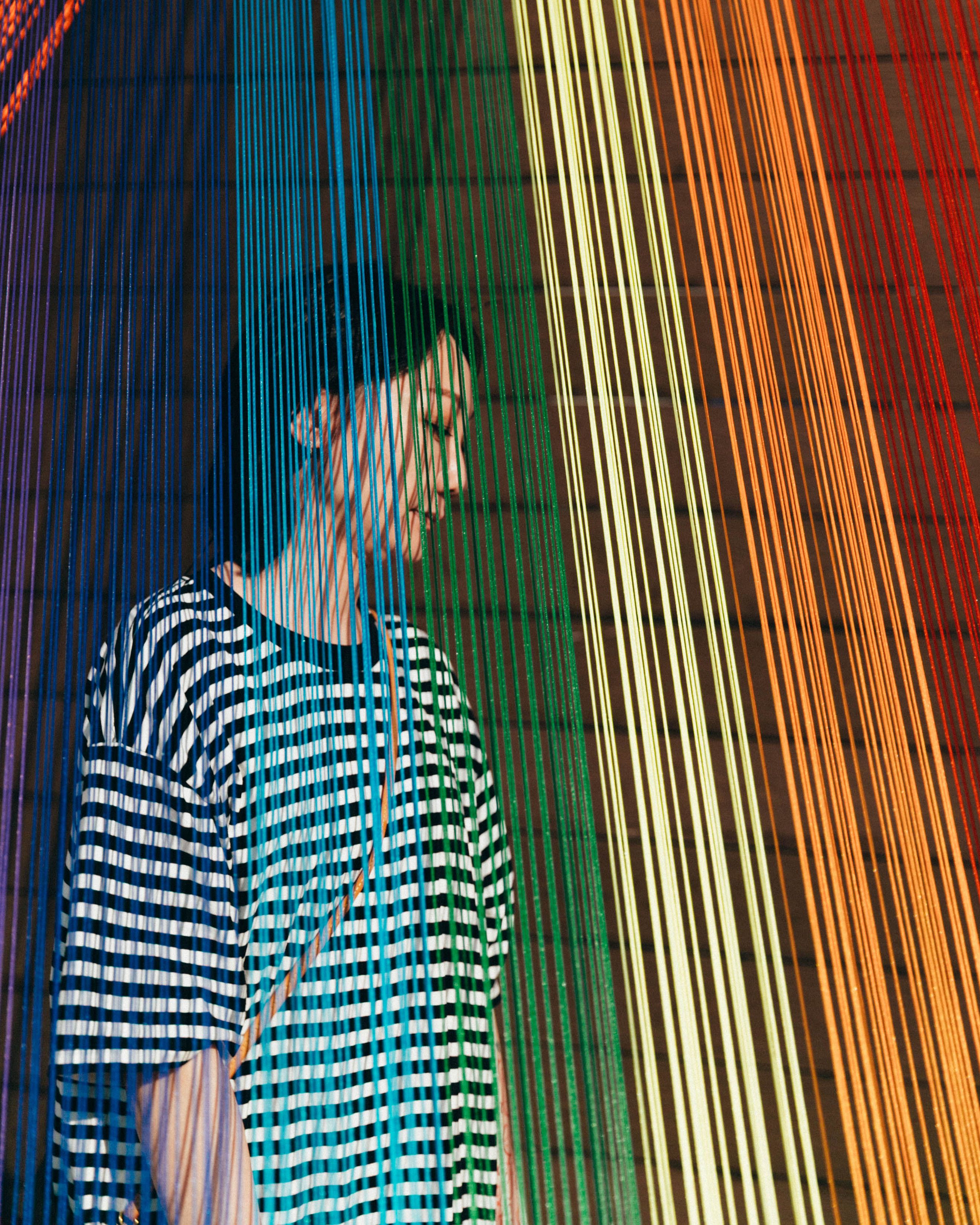 Portrait of Person Behind Colorful Strands Indoors · Free Stock Photo
