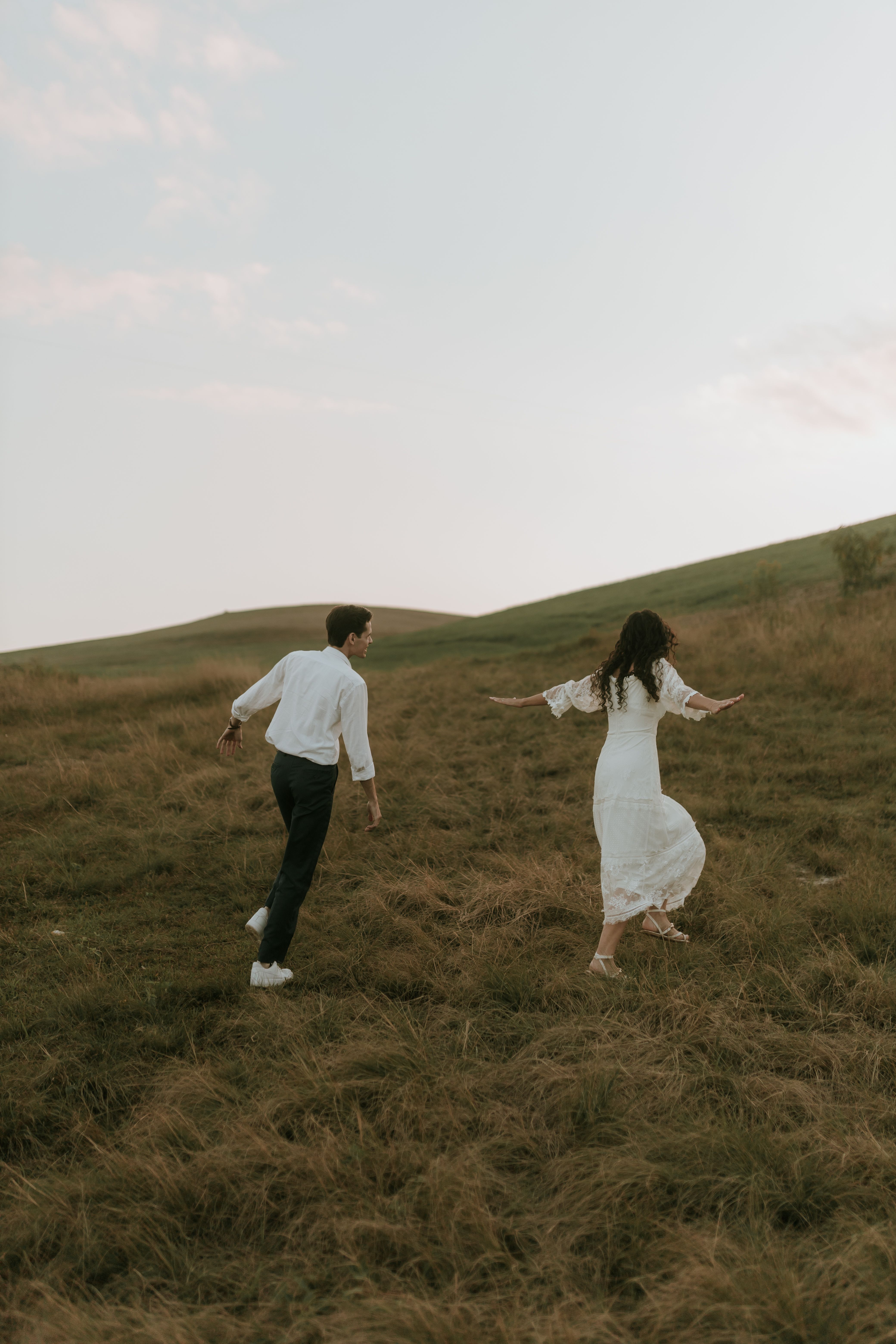 Couple Running Freely in Open Field at Dusk · Free Stock Photo