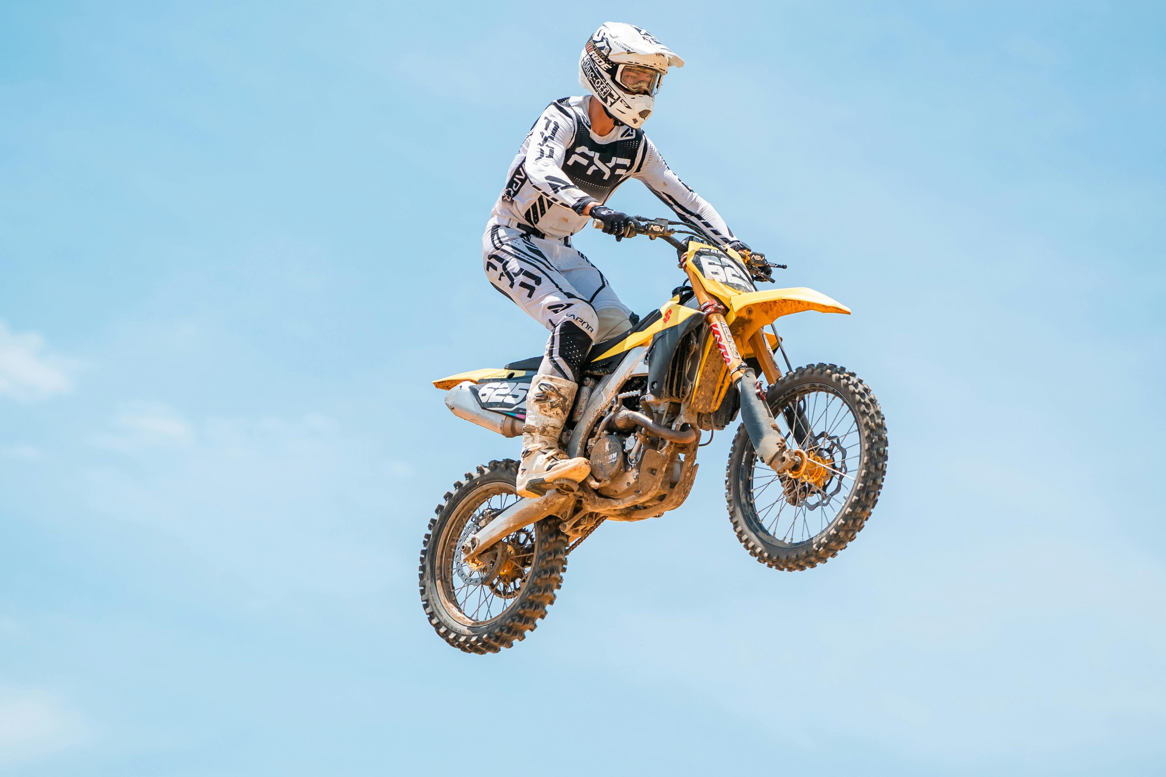 Motocross Rider Mid-Air Jump Against Clear Sky · Free Stock Photo