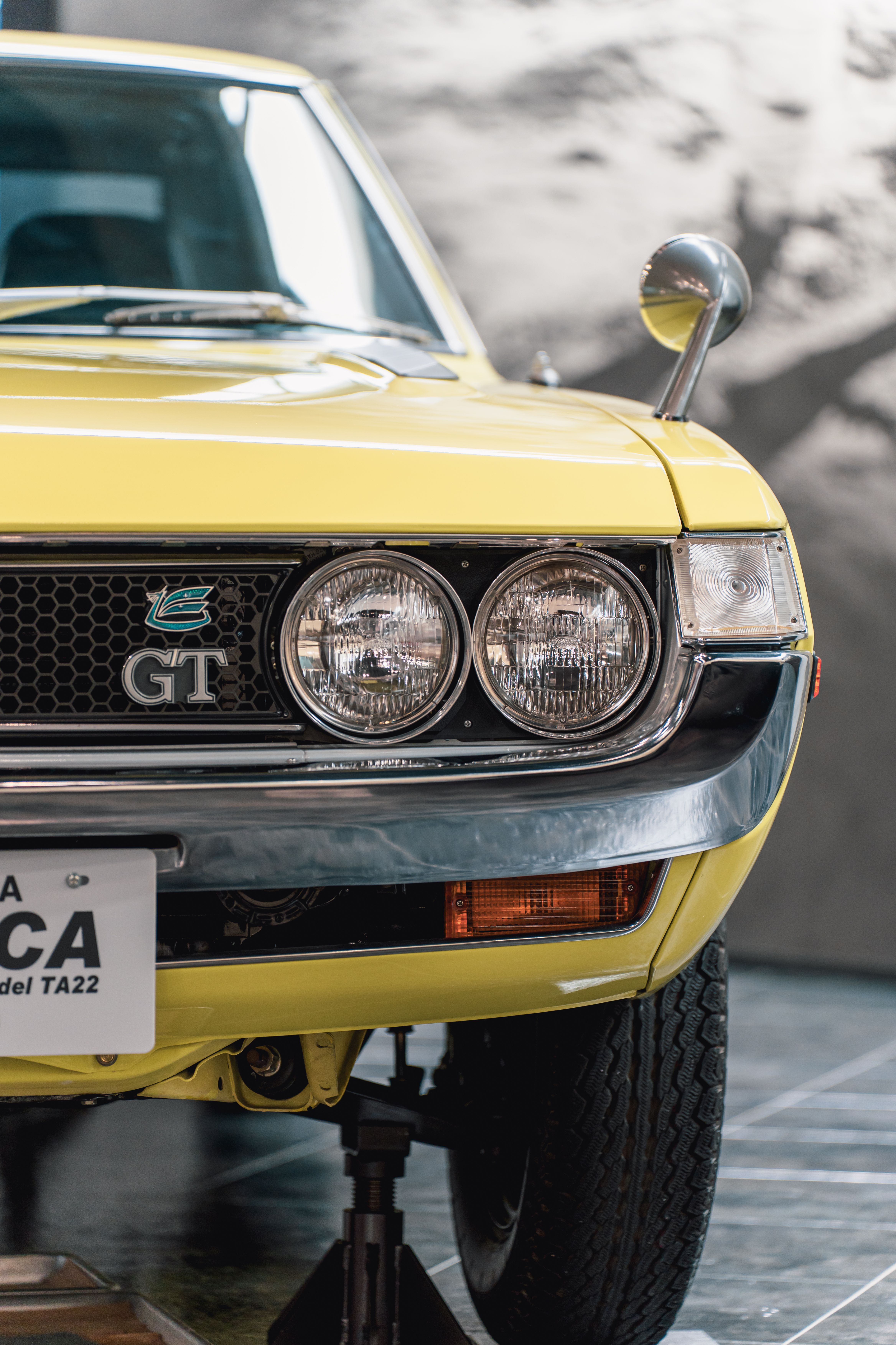 Vintage Yellow GT Car Front View in Showroom · Free Stock Photo