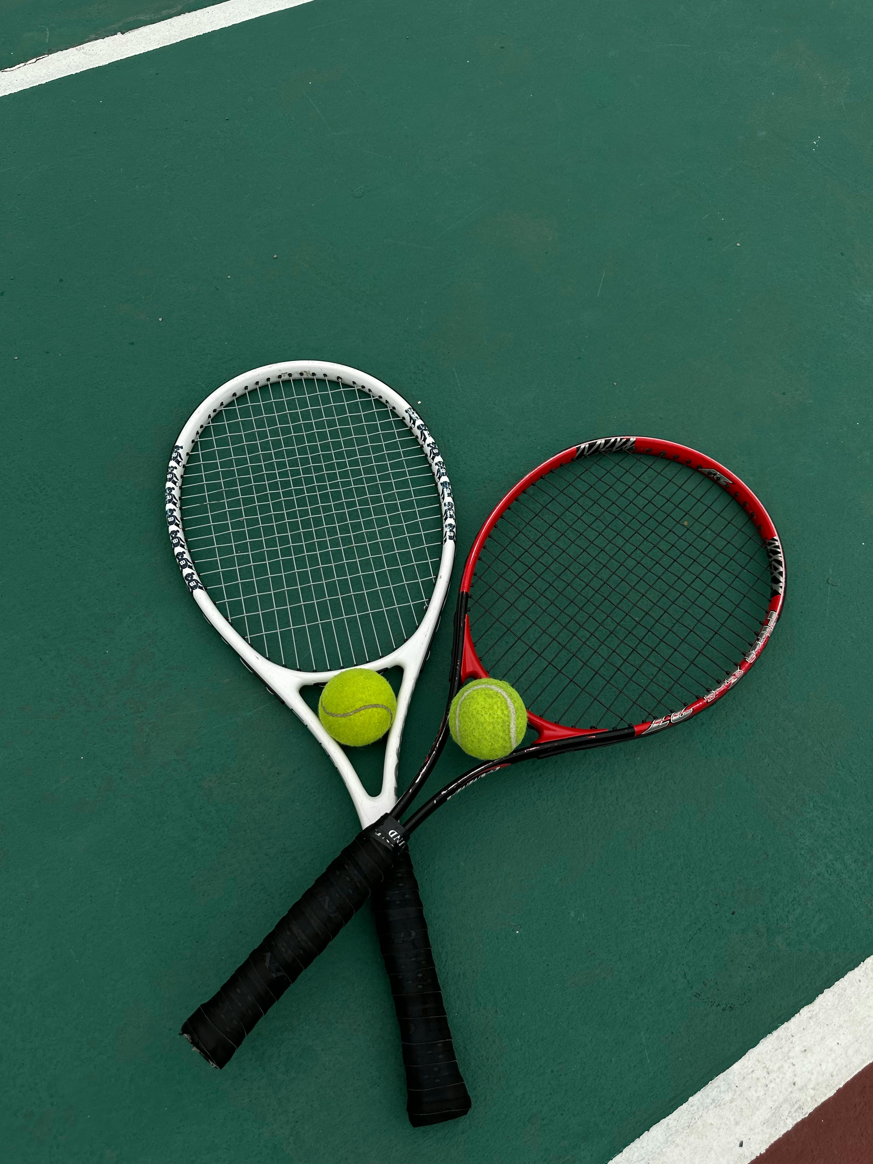 Pair of Tennis Rackets with Tennis Balls on Court · Free Stock Photo