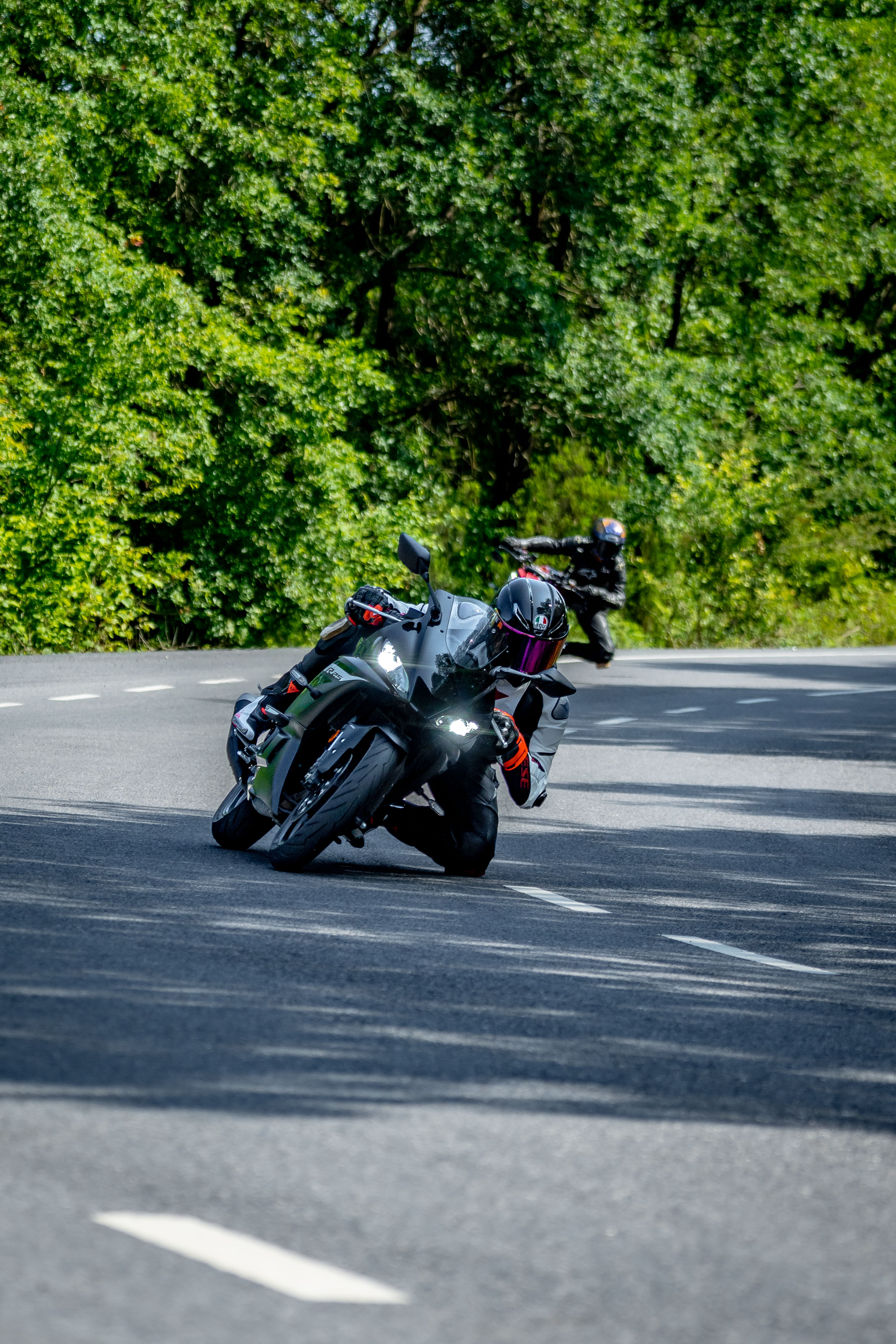 Motorcyclists Leaning in Sharp Turn on Scenic Road · Free Stock Photo