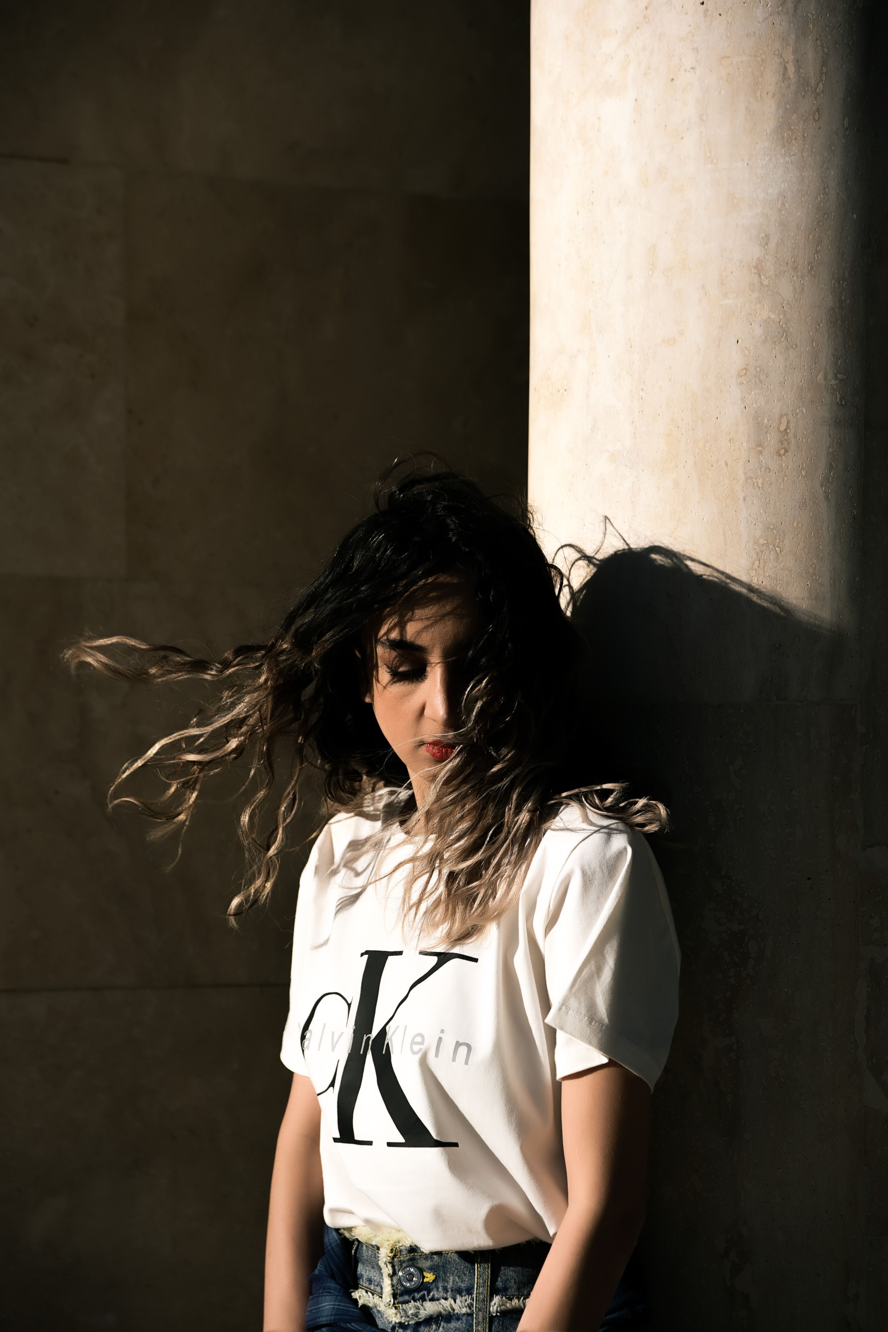 Fashionable Woman in Sunlight with Windblown Hair · Free Stock Photo