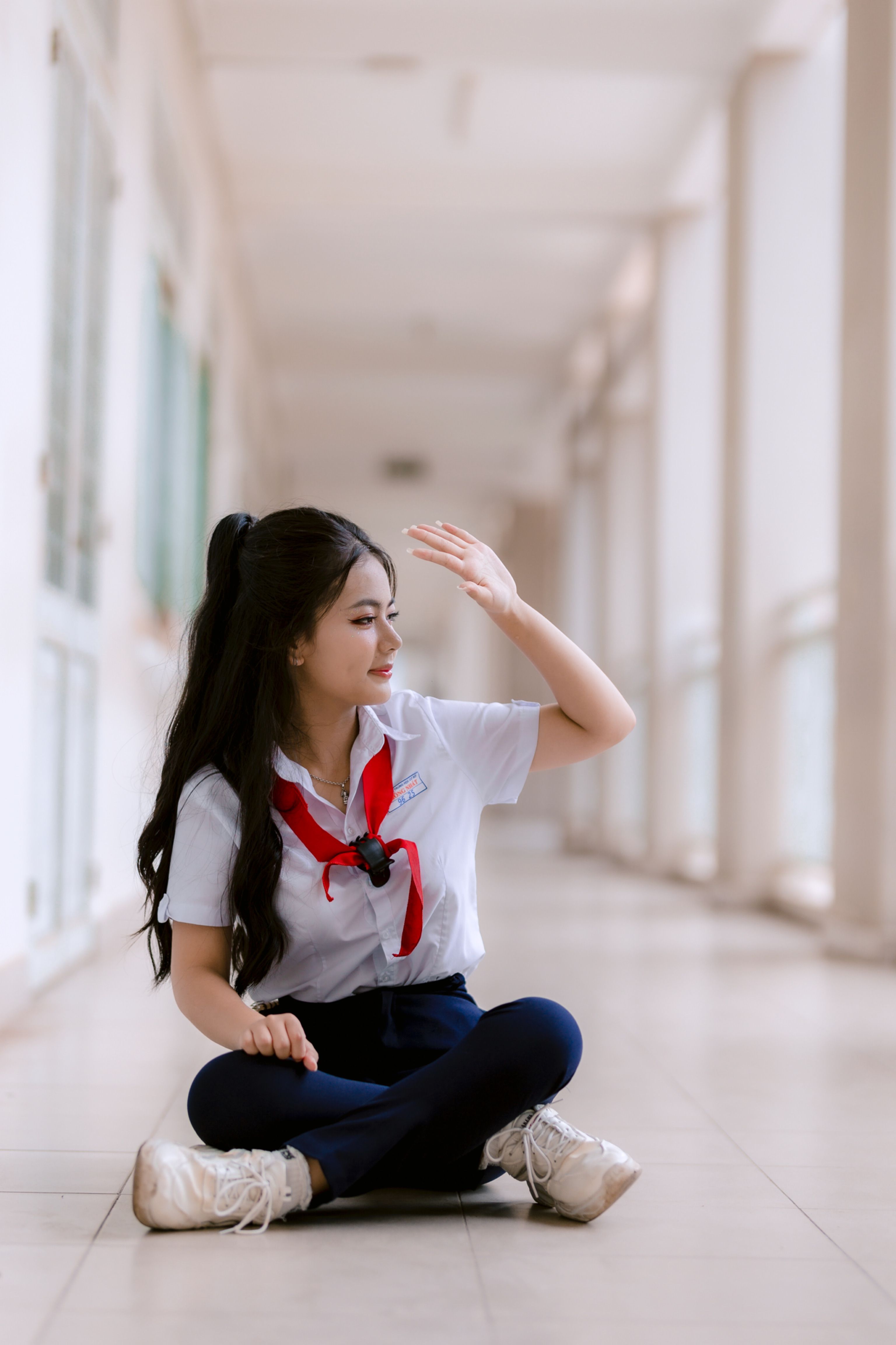 Student in School Uniform Sitting in Hallway · Free Stock Photo