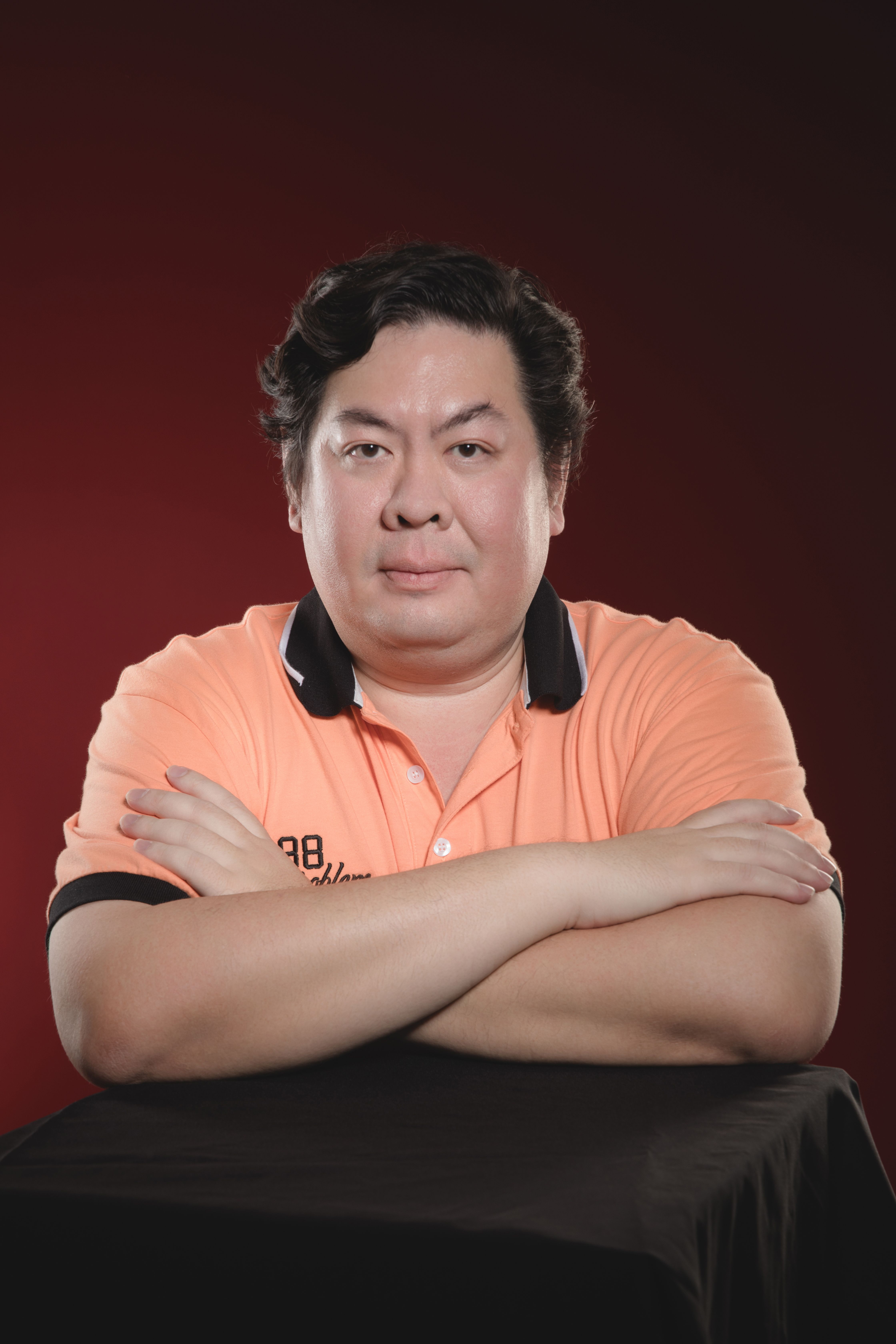 Portrait of Man in Orange Polo Shirt on Dark Background · Free Stock Photo