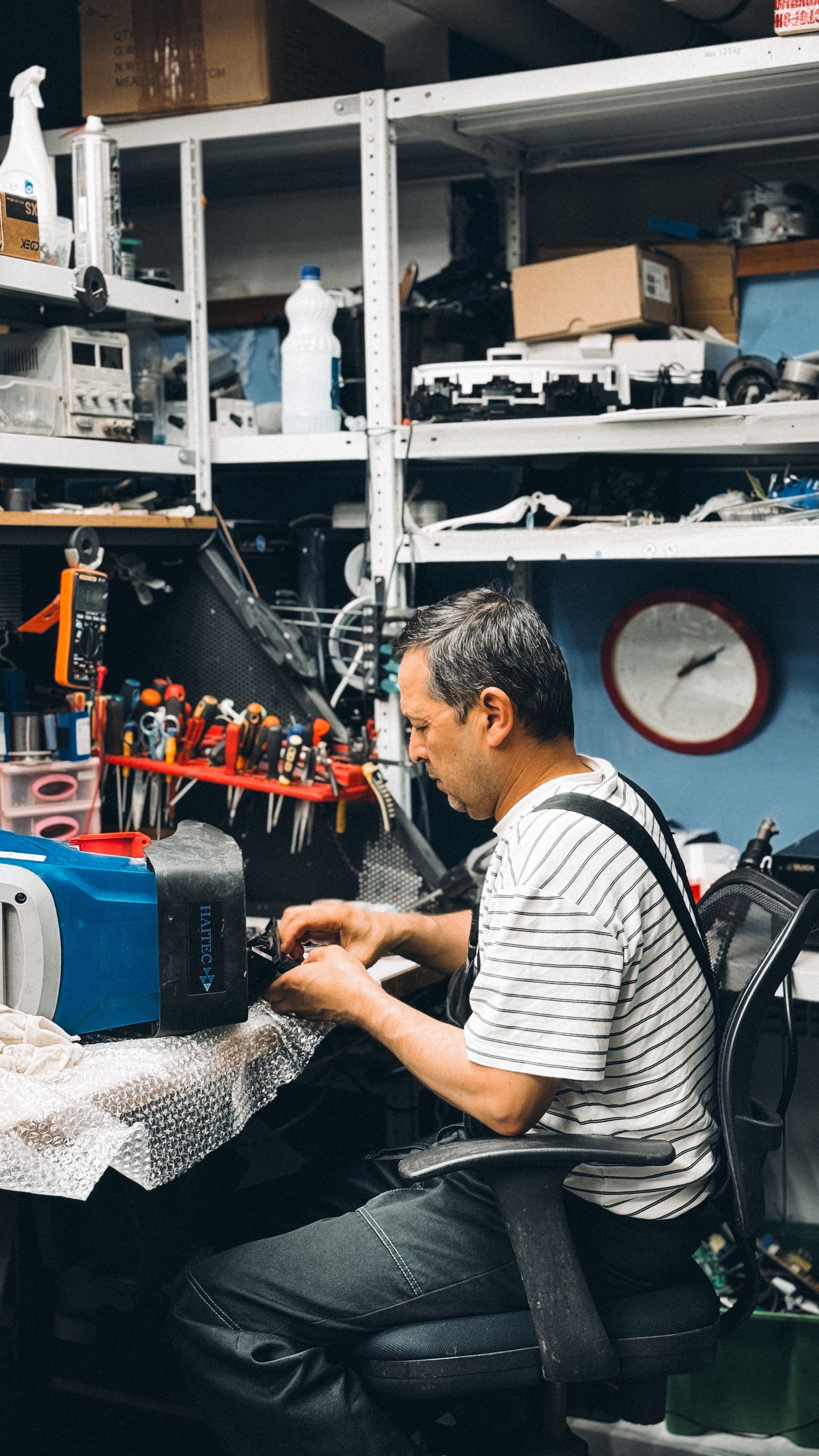 Engineer Working on Laptop in Workshop Setting · Free Stock Photo