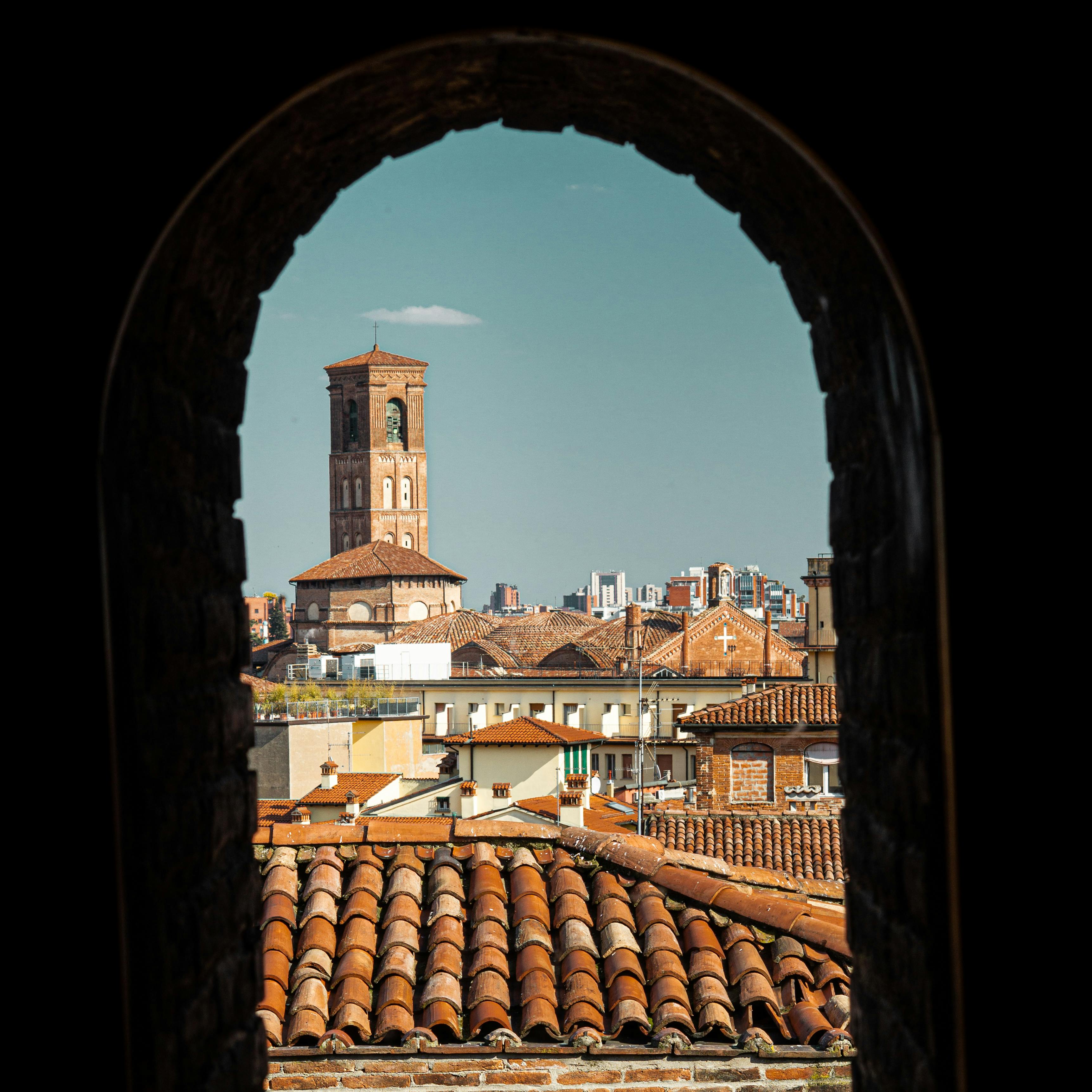 Charming Italian Cityscape through Arched Window · Free Stock Photo