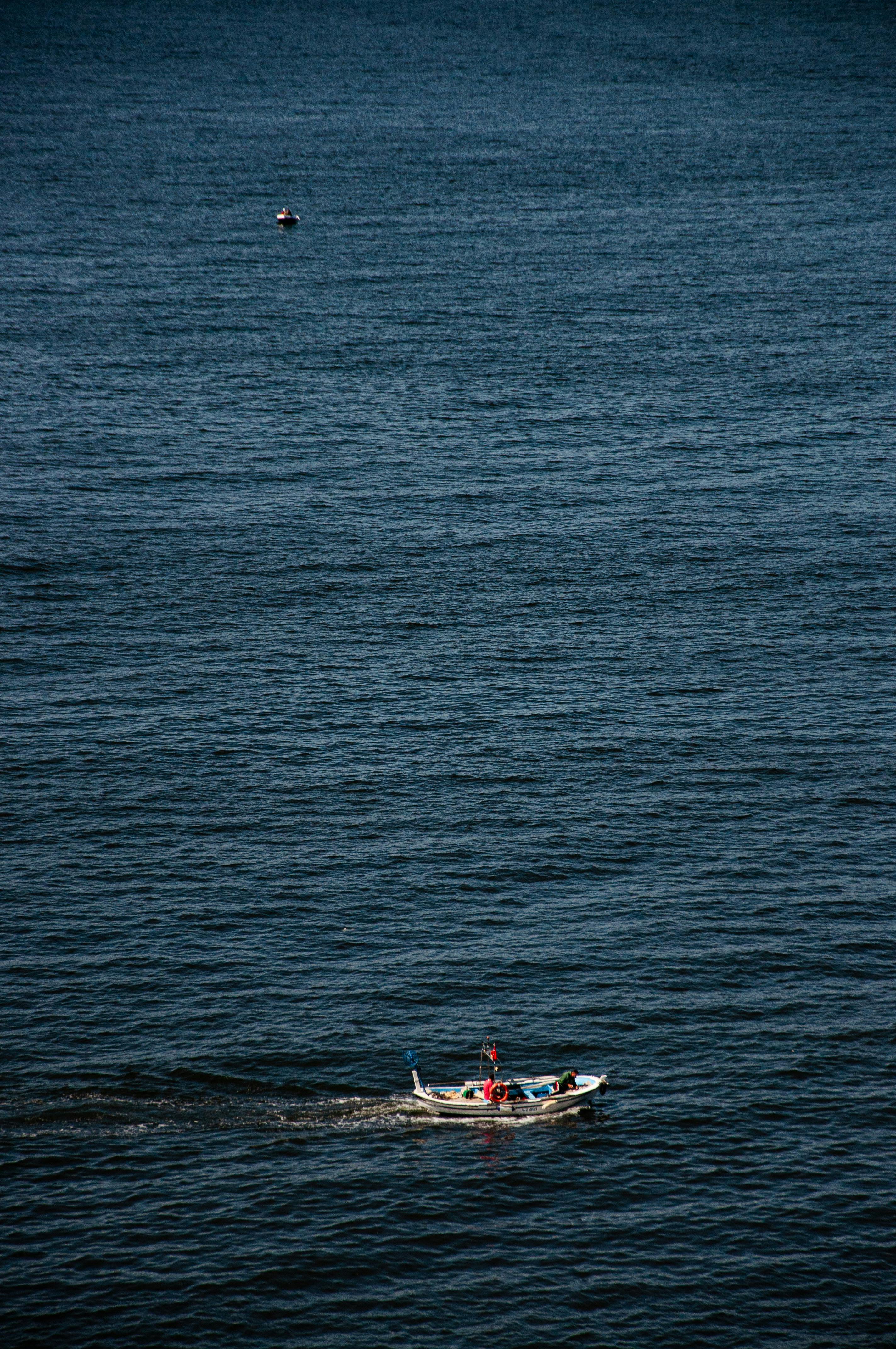 Small Boat Navigating Vast Ocean Water · Free Stock Photo