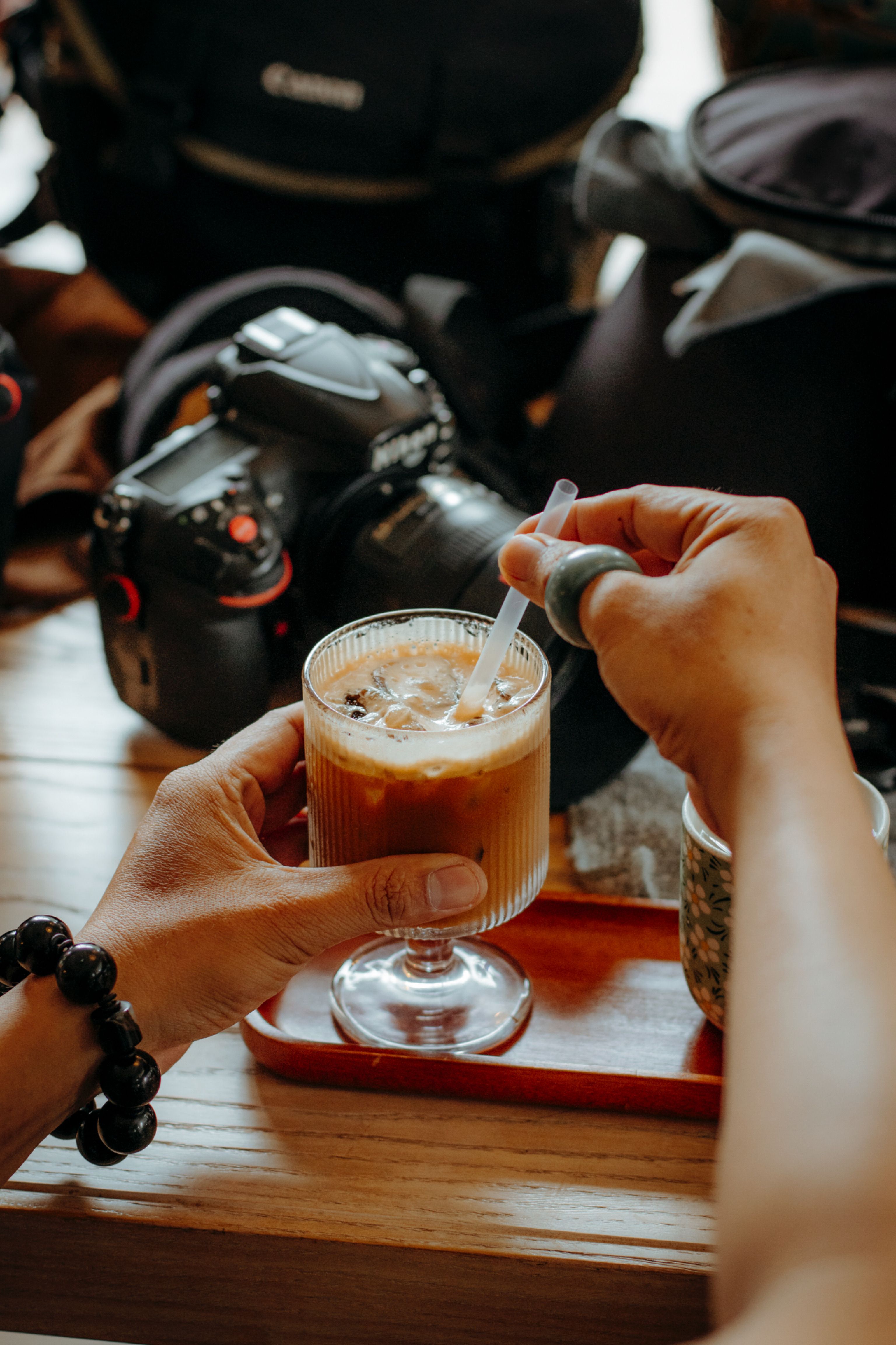 Hands Stirring Iced Coffee Next to Camera · Free Stock Photo