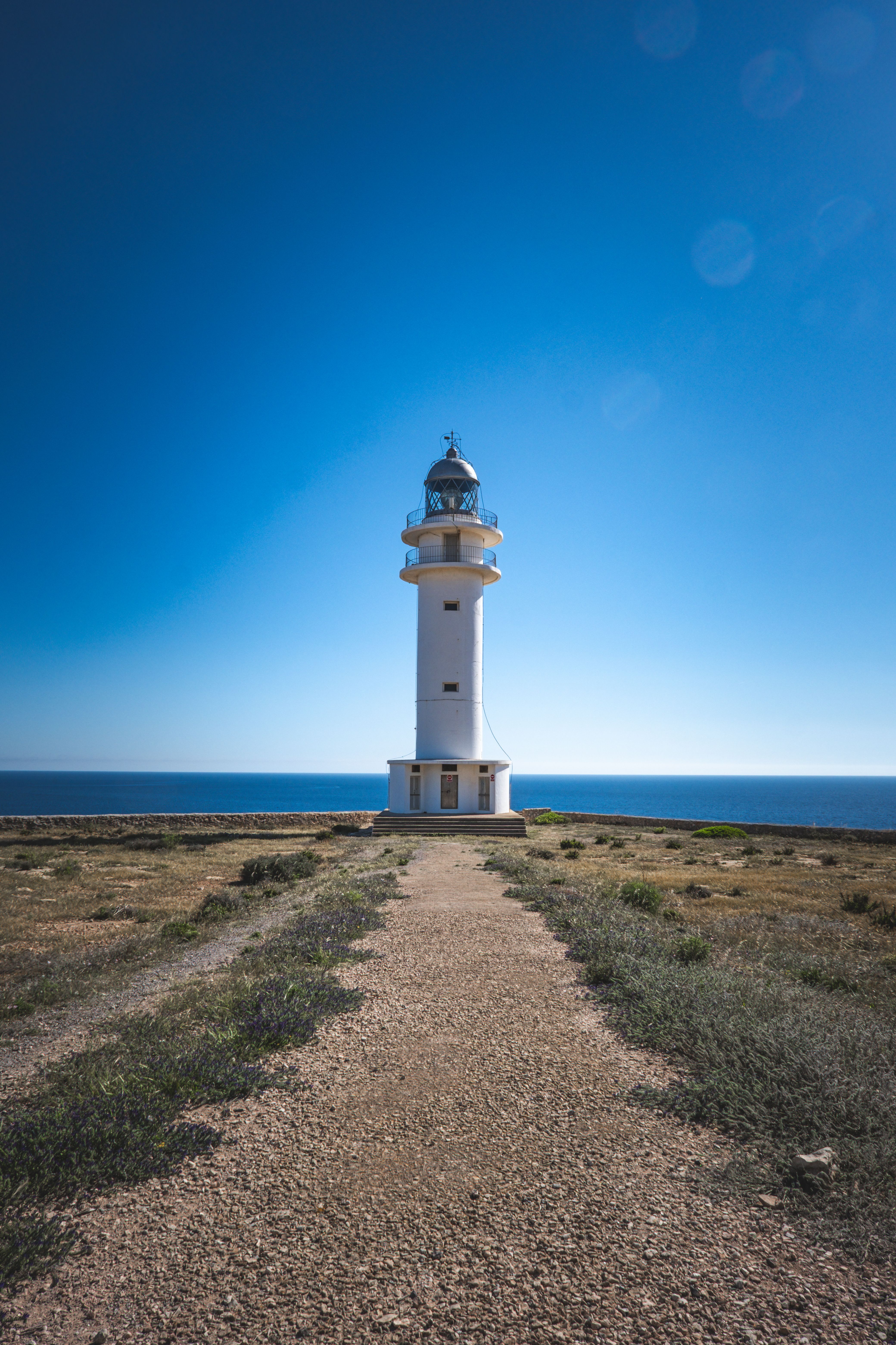Majestuoso Faro Costero Bajo Un Cielo Azul Claro · Foto de stock gratuita