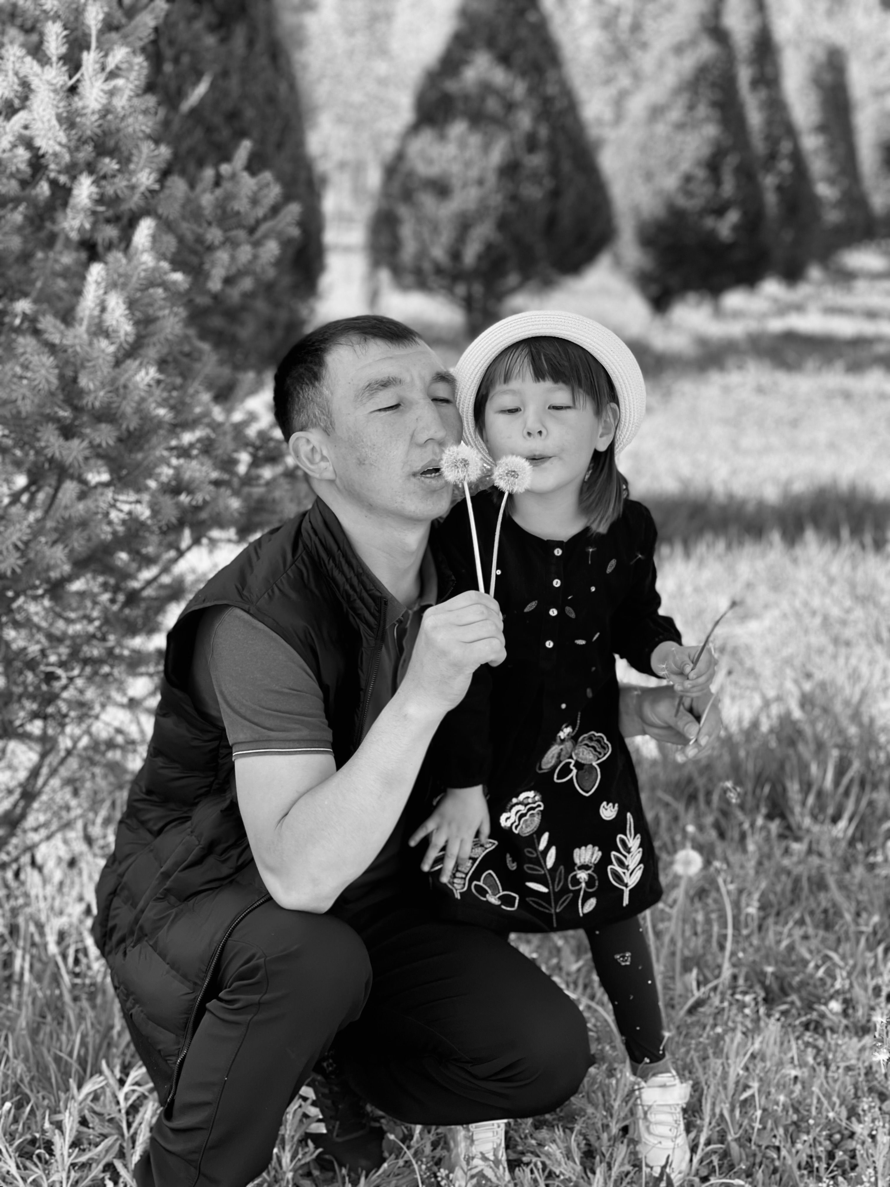 Father and Daughter Blowing Dandelions Outdoors · Free Stock Photo