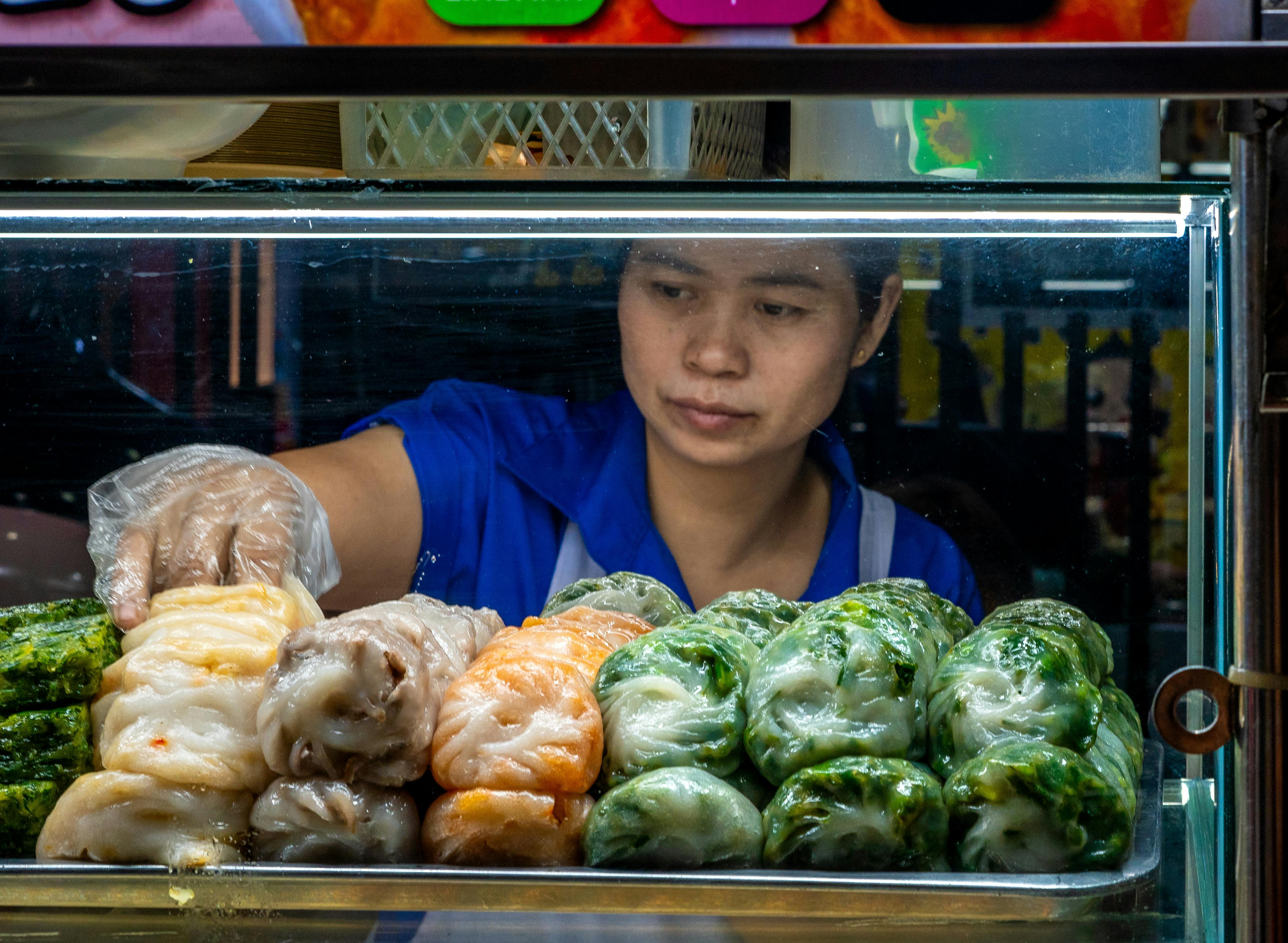 Street Vendor Arranging Colorful Dumplings Display · Free Stock Photo