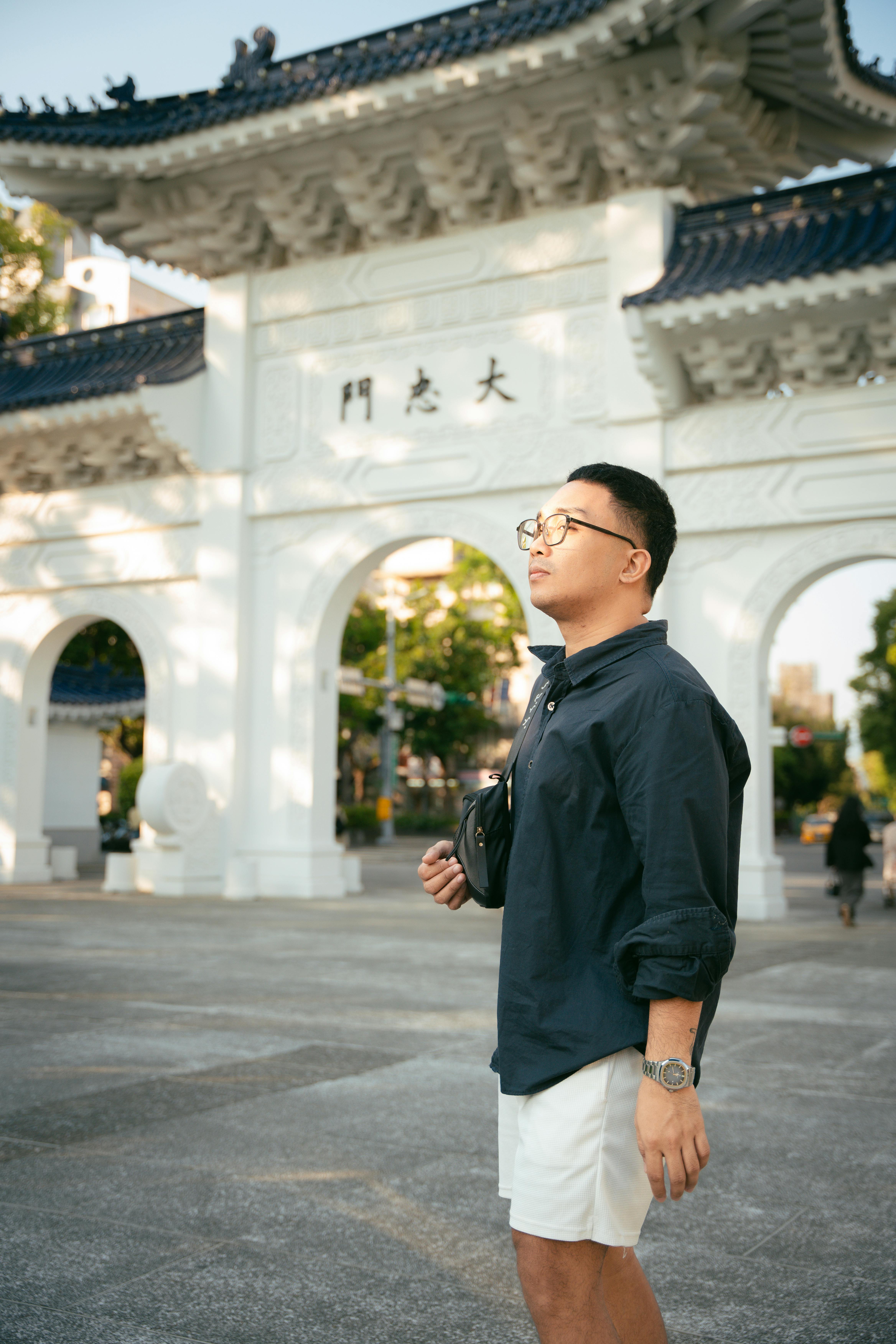 Young Man Exploring Historical Landmark Gate · Free Stock Photo