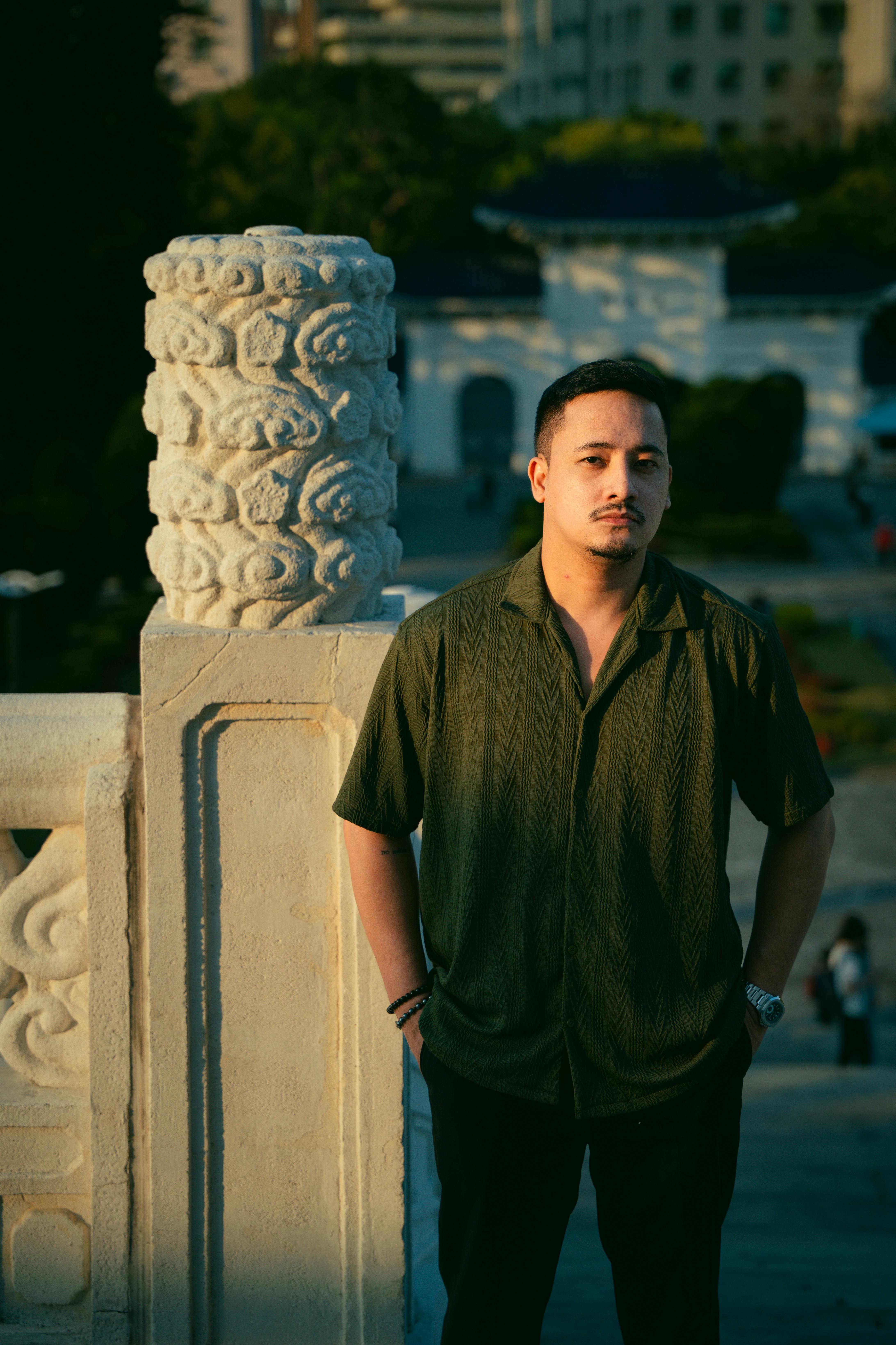 Man Standing by Ornate Stone Railing at Dusk · Free Stock Photo