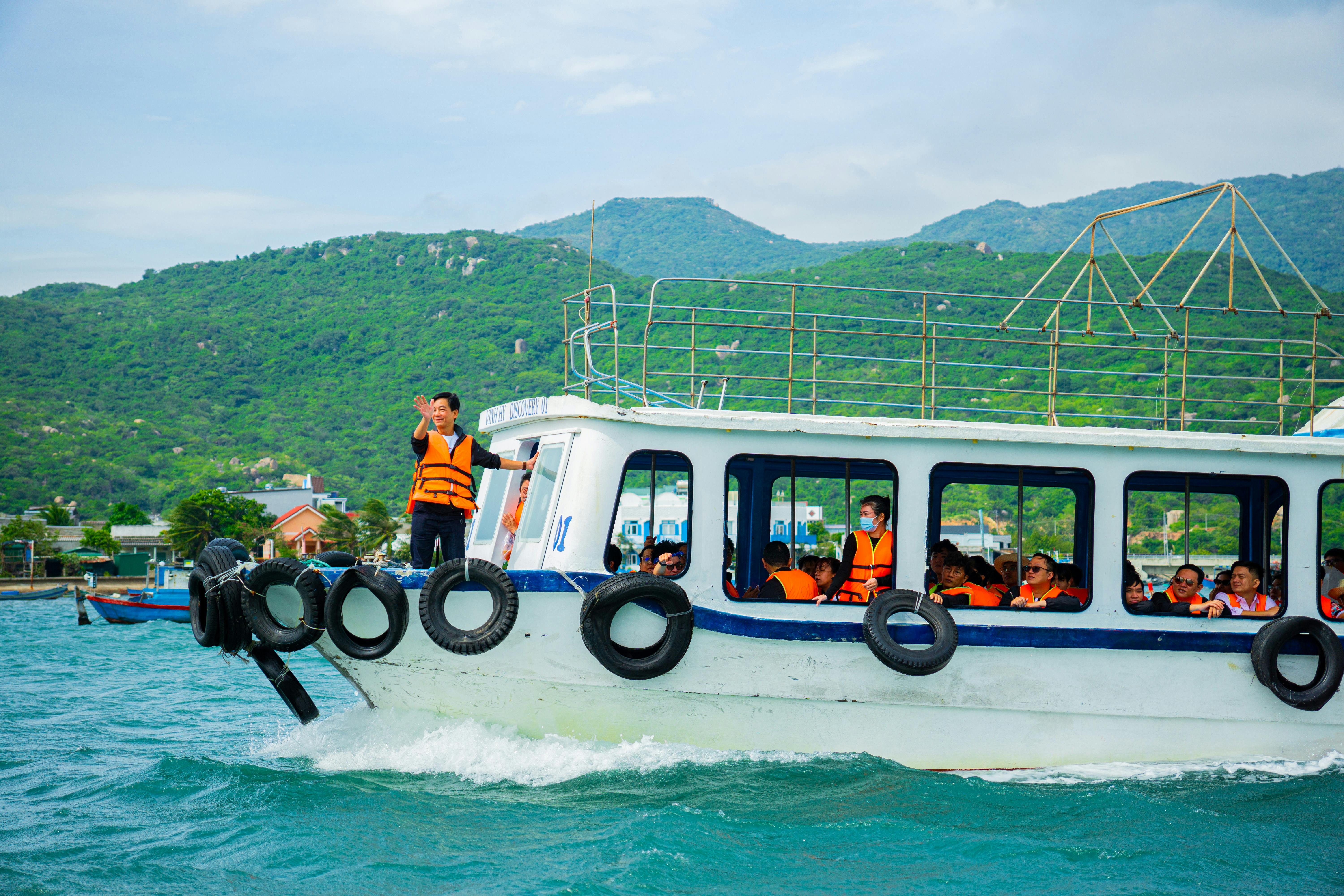 Tourists Enjoying Scenic Boat Ride Near Mountains · Free Stock Photo