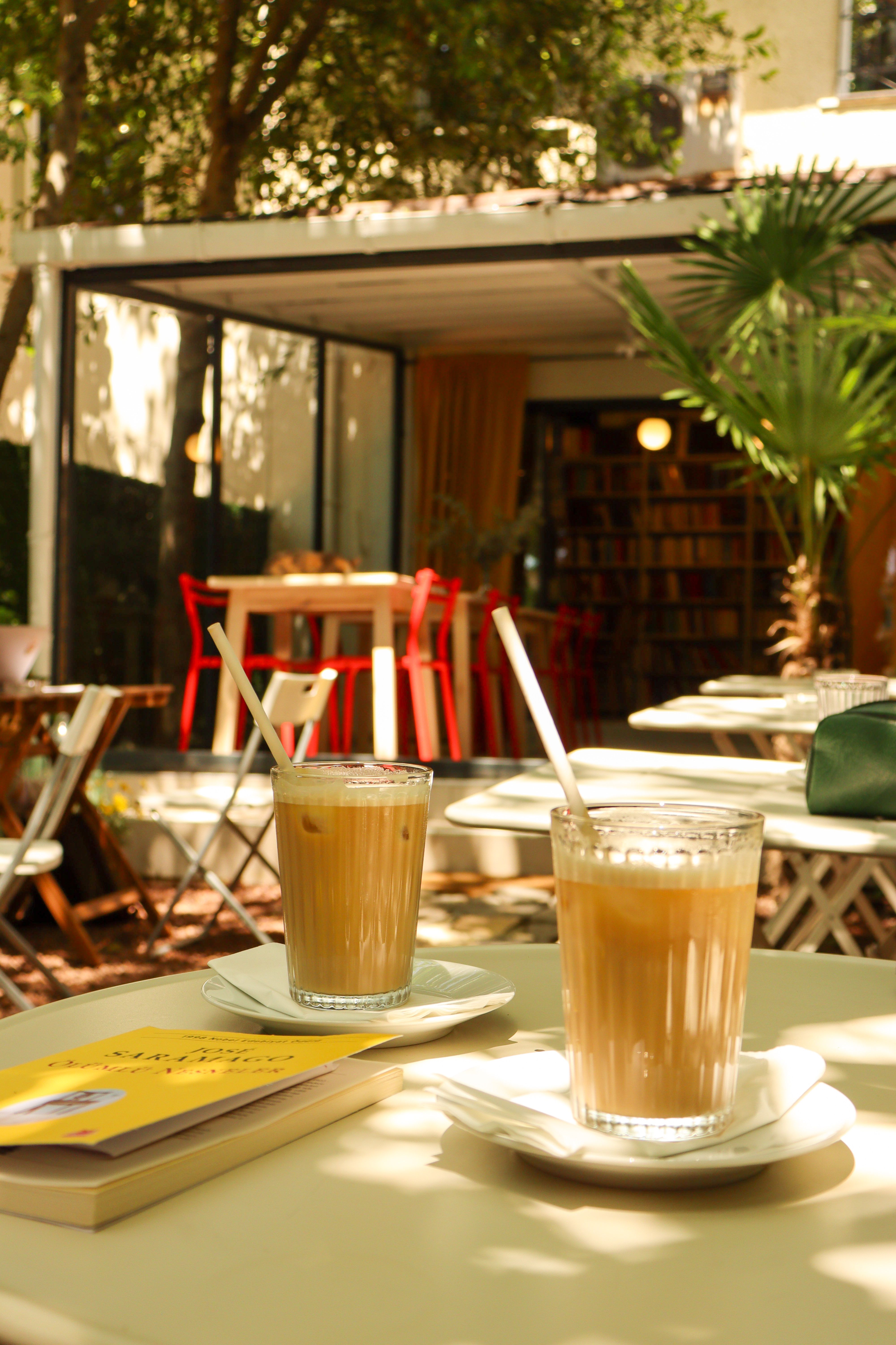 Cozy Outdoor Café with Iced Coffee and Books · Free Stock Photo