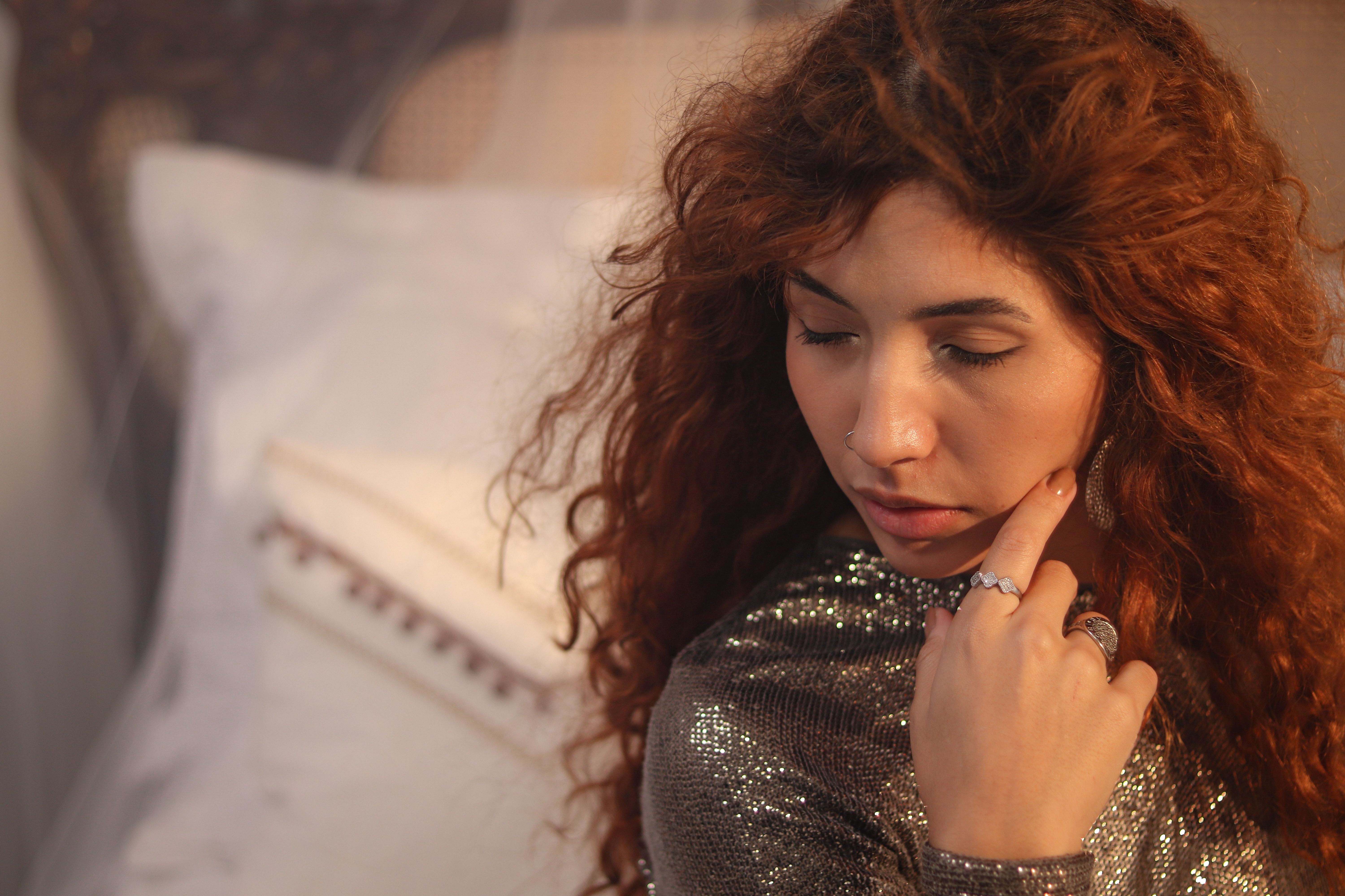 Contemplative Woman in Sparkling Outfit Indoors · Free Stock Photo