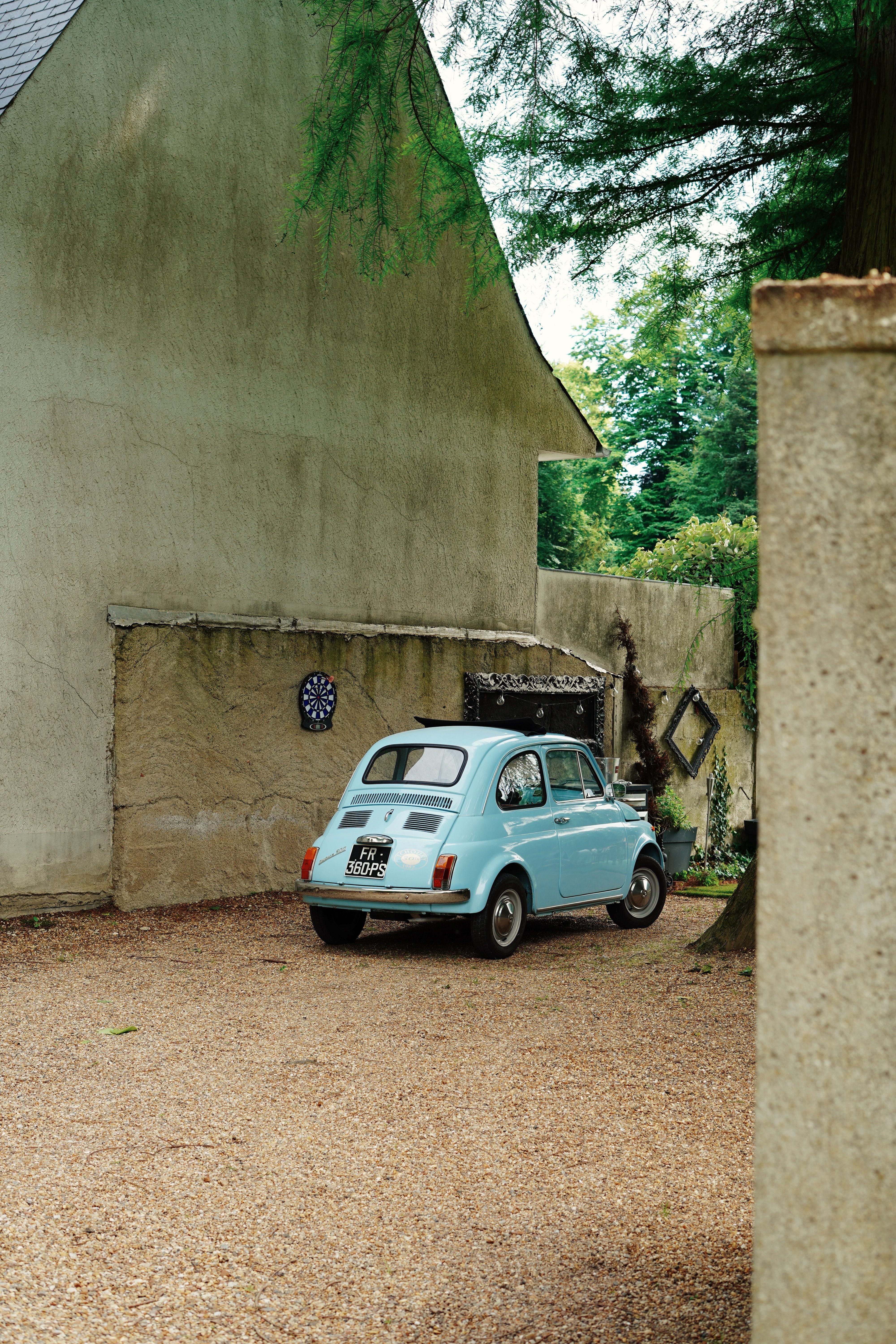 Vintage Blue Car Parked in Rustic Courtyard · Free Stock Photo