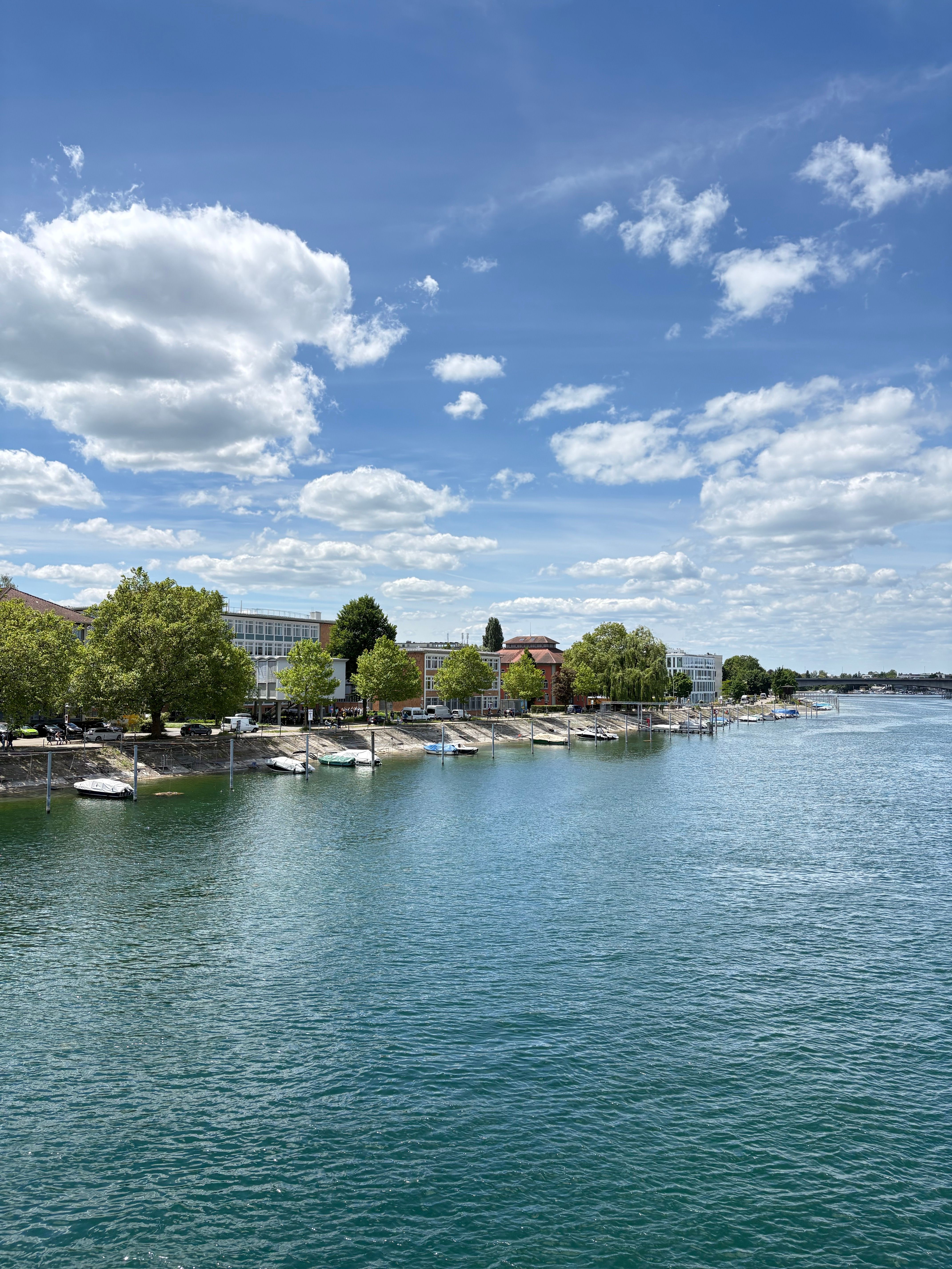 Scenic Riverside View with Boats and Cloudy Sky · Free Stock Photo